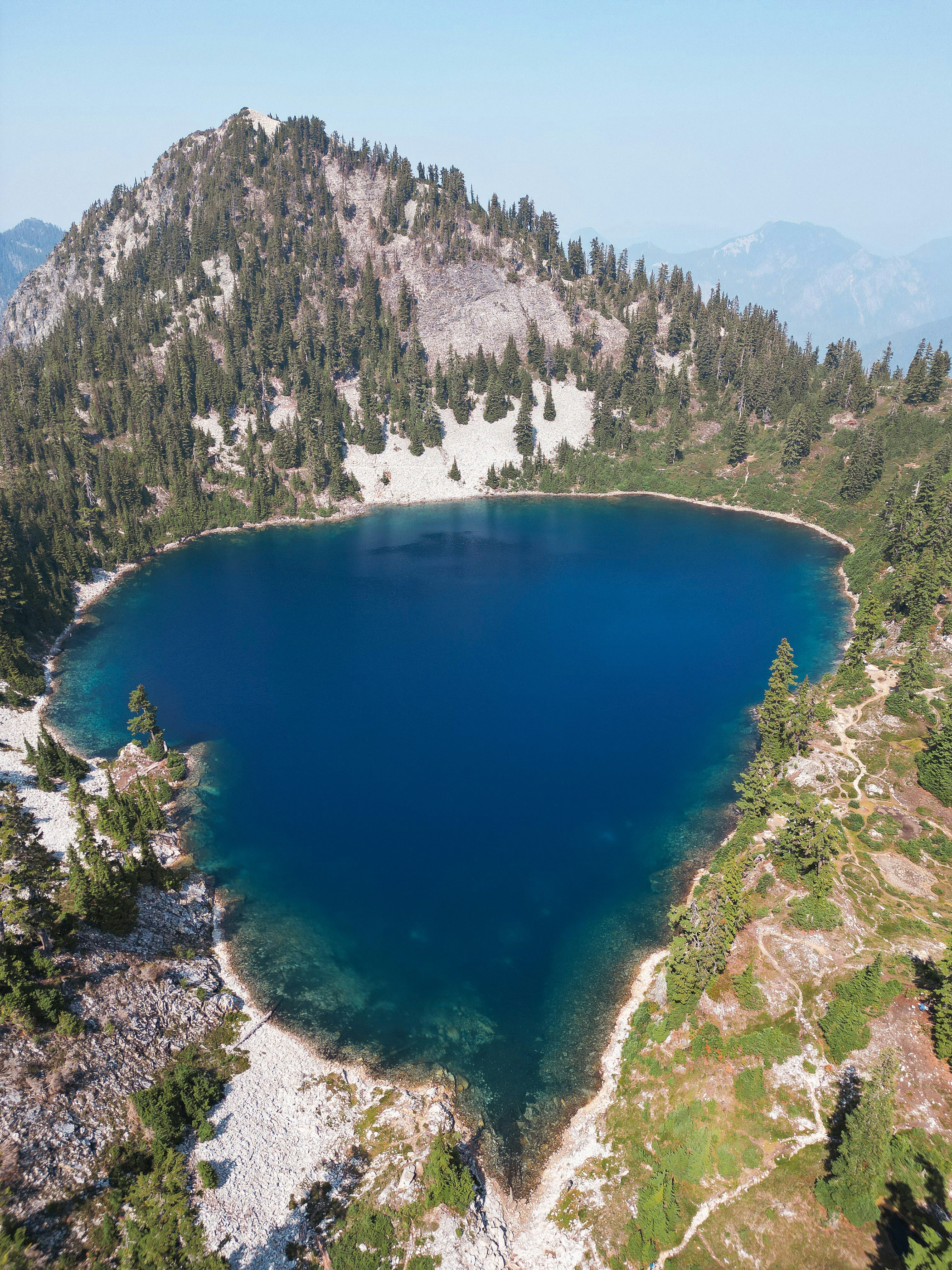 Foto Un gran lago azul rodeado de montañas y árboles – Imagen Estados ...