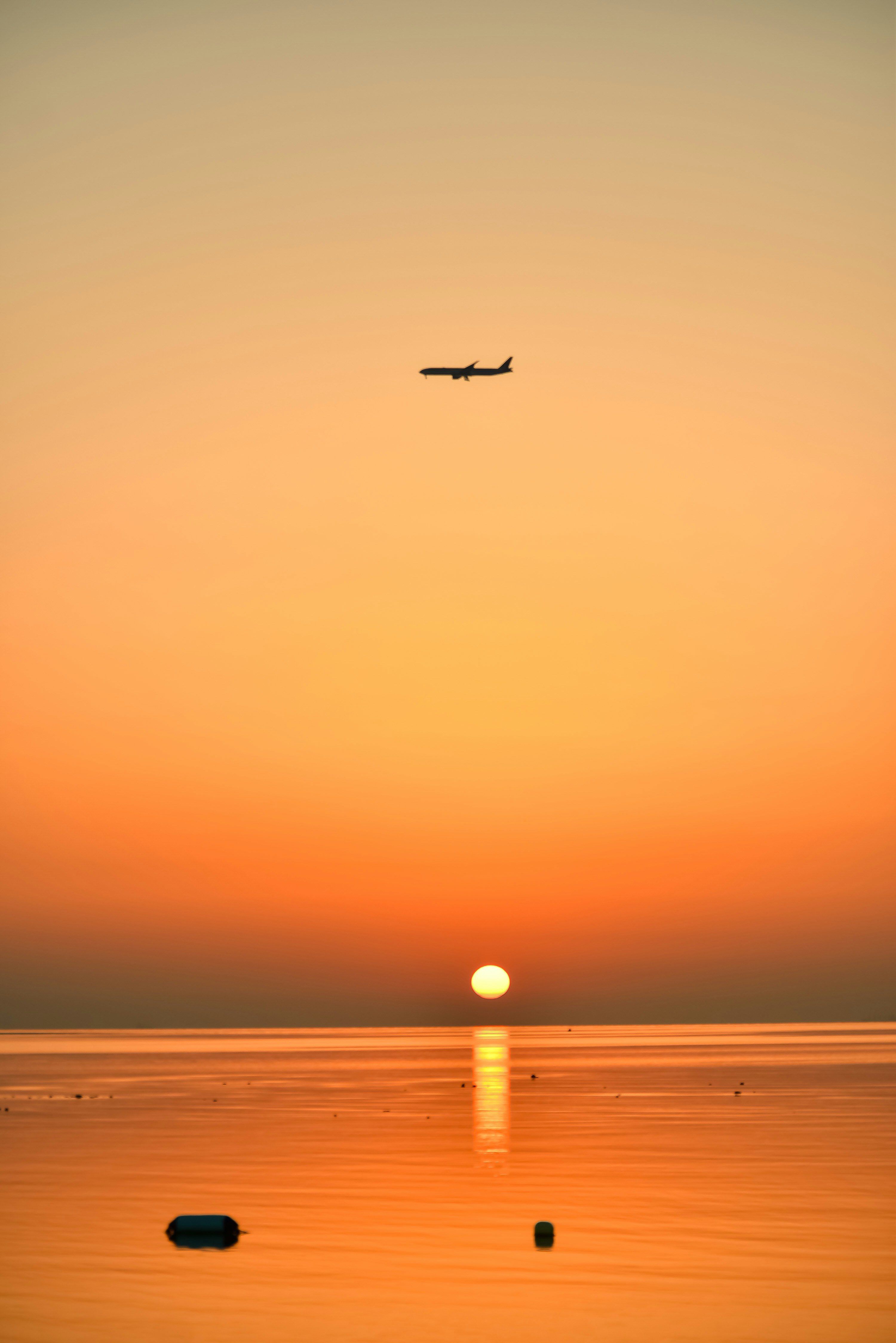 Jet Over Ember Seas: A Sunset Silhouette