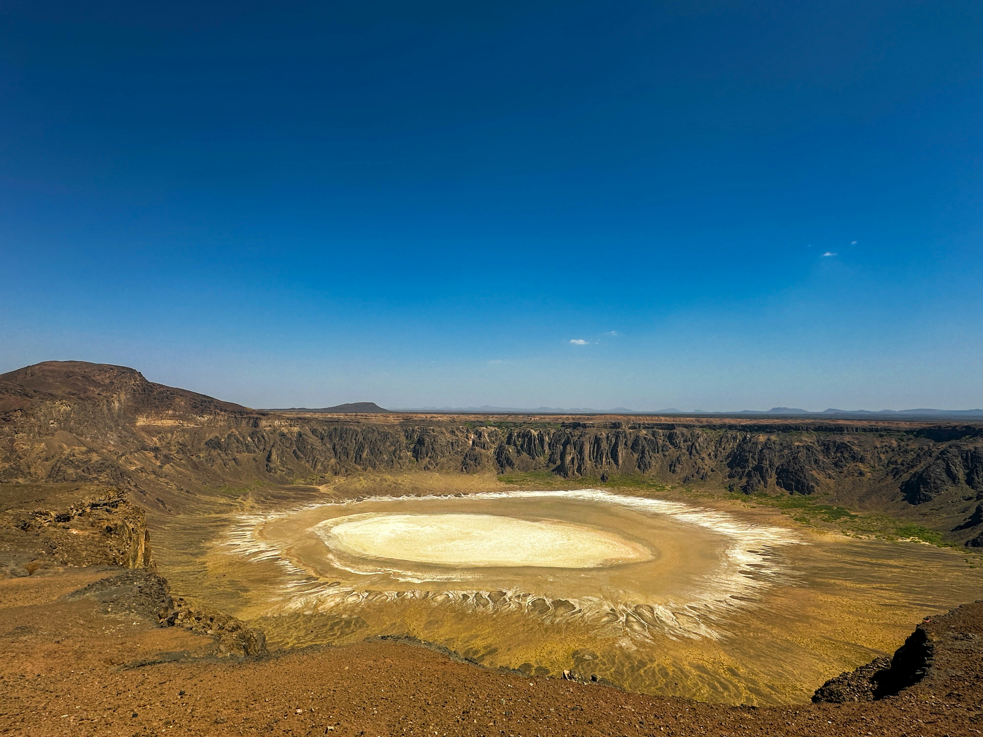 A large crater in the middle of a desert photo – Free Volcano Image on ...
