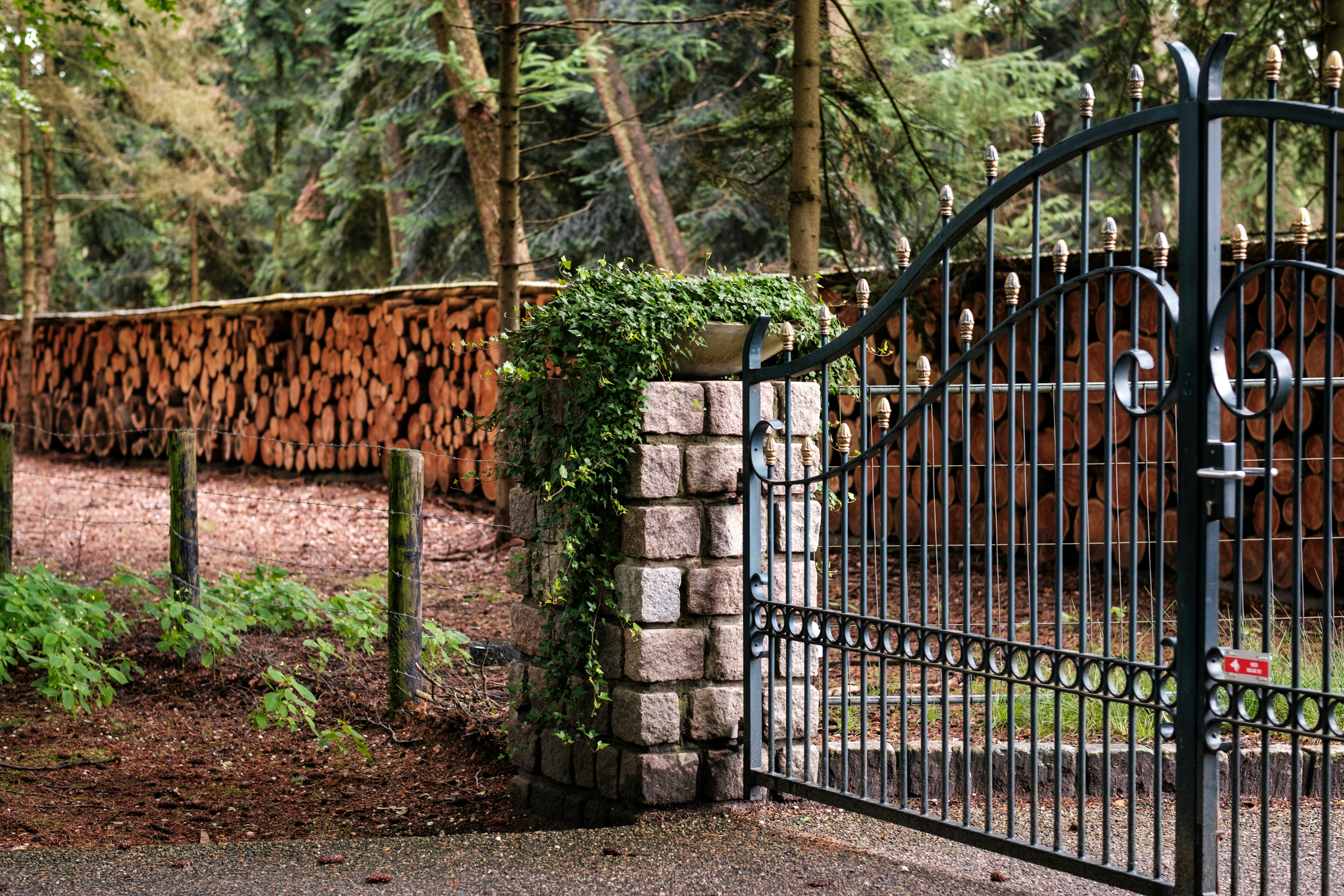 A gate with a bunch of logs behind it photo – Free Gate Image on Unsplash