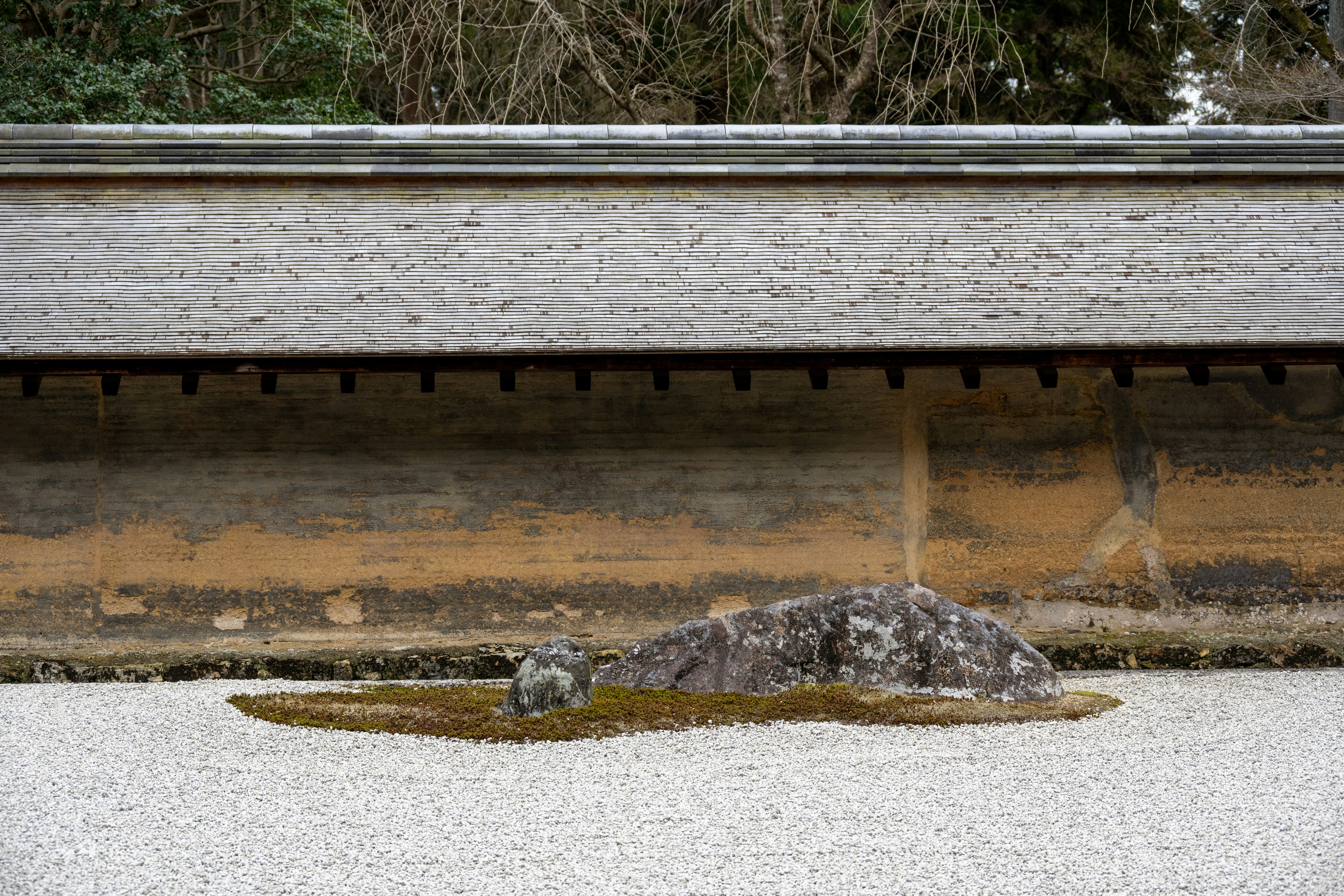 Zen Gravel and Stone under a Weathered Wall