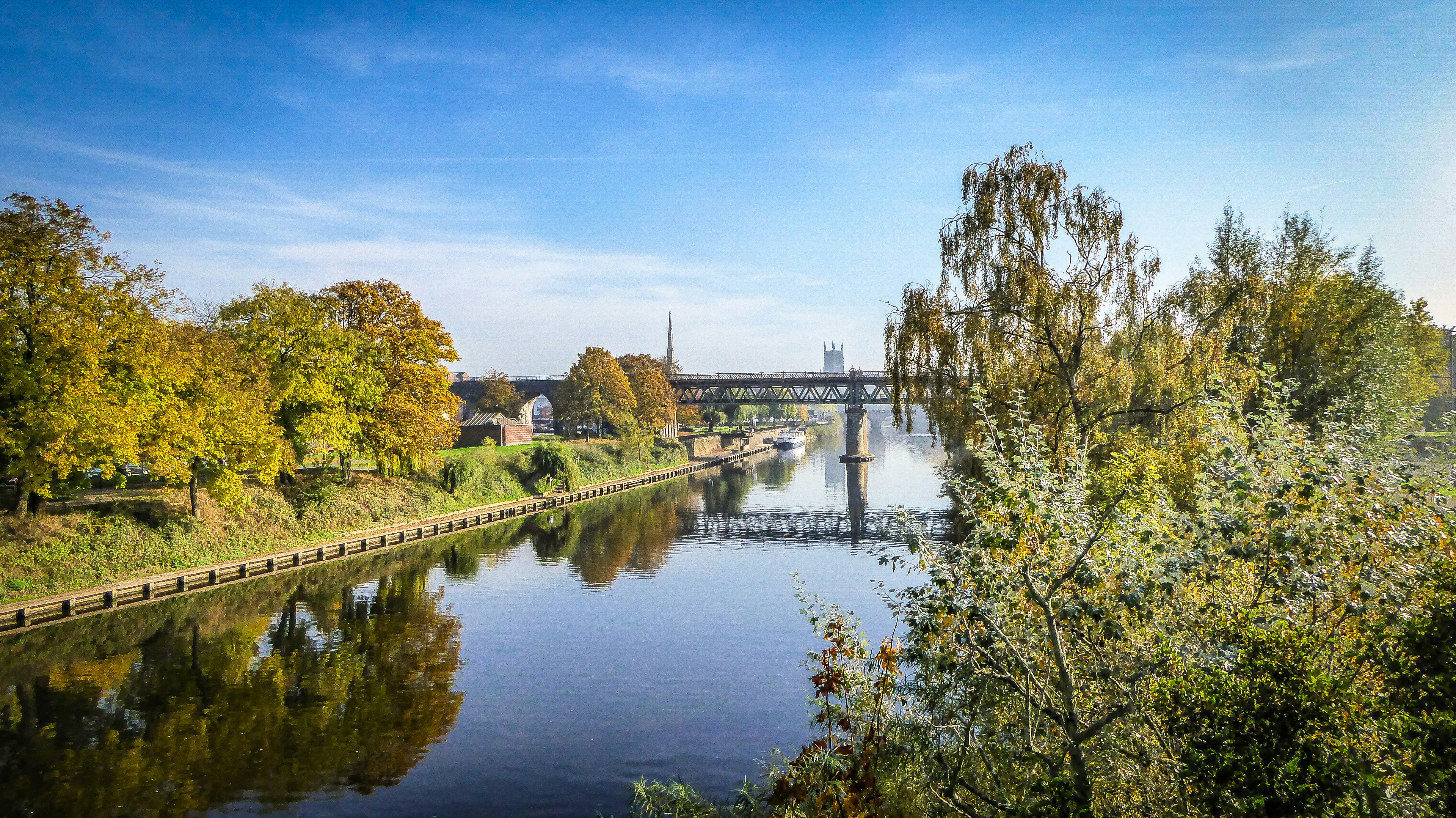 Bridge over River Severn surrounded by autumn foliage under a clear blue sky.