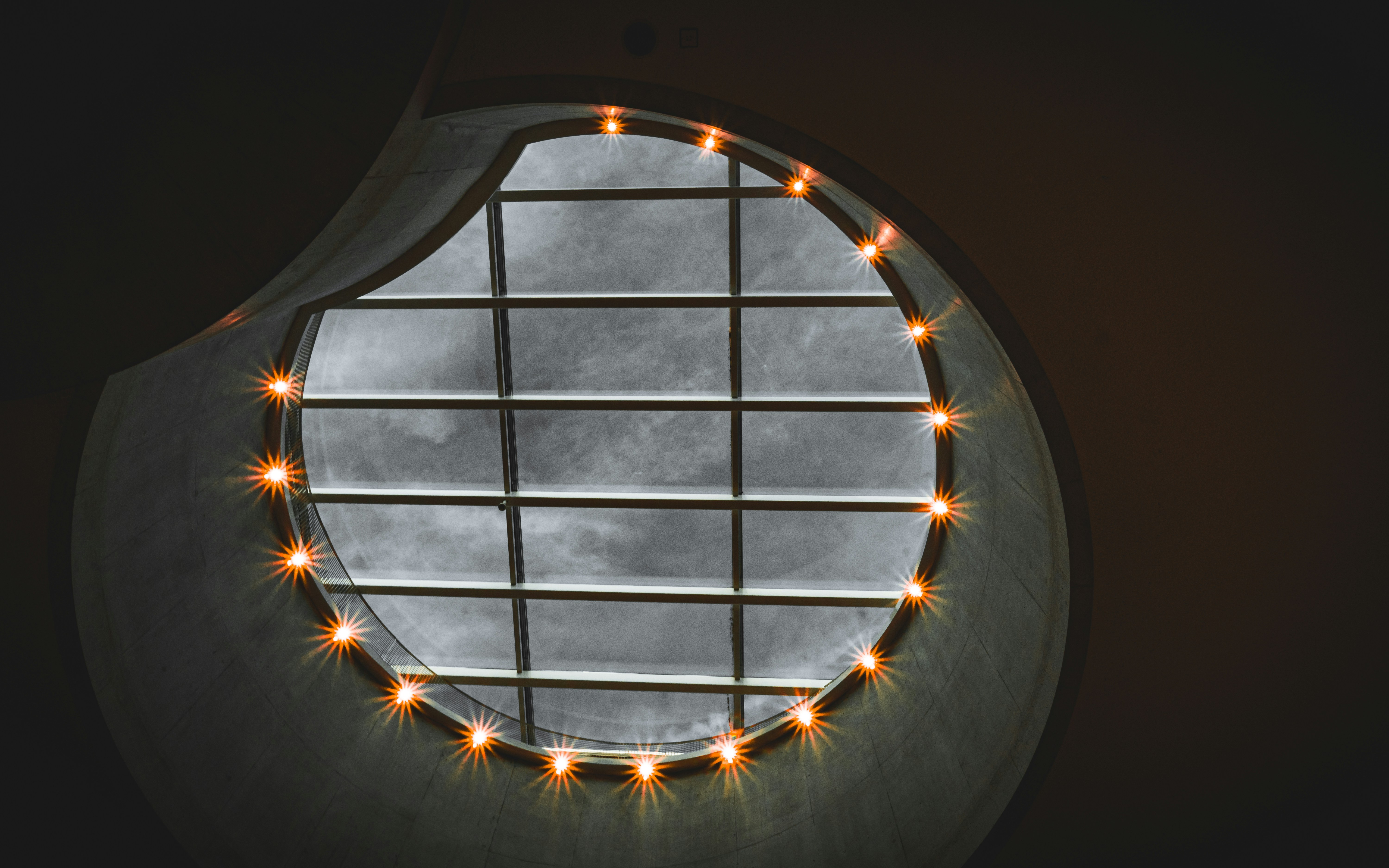 Haloed Circular Window: Grid, Glow, and a Cloudy View