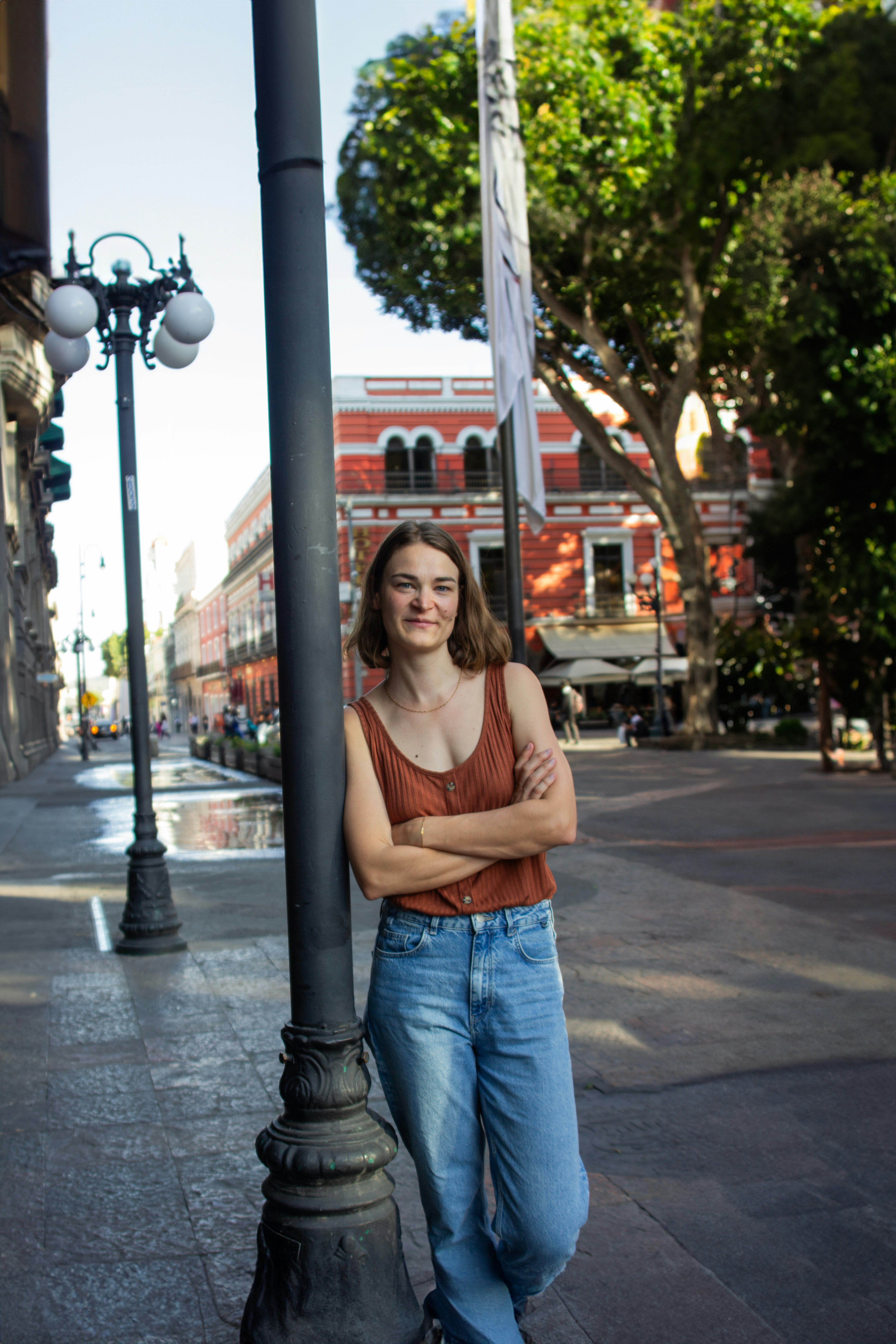 A woman leaning against a lamp post on a city street photo – Free # ...