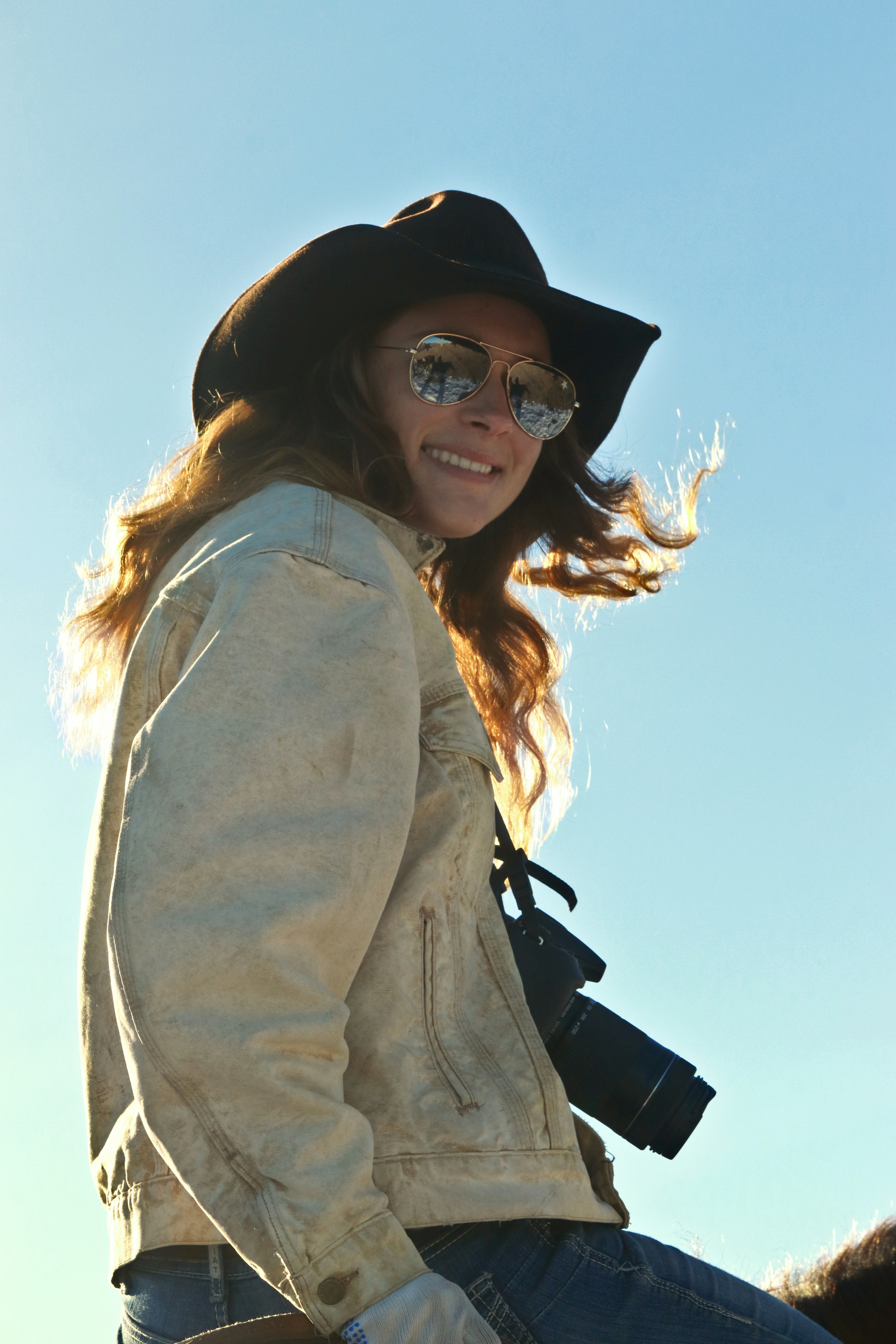 Sunlit Smile: Wind-Swept Portrait in a Cowboy Hat