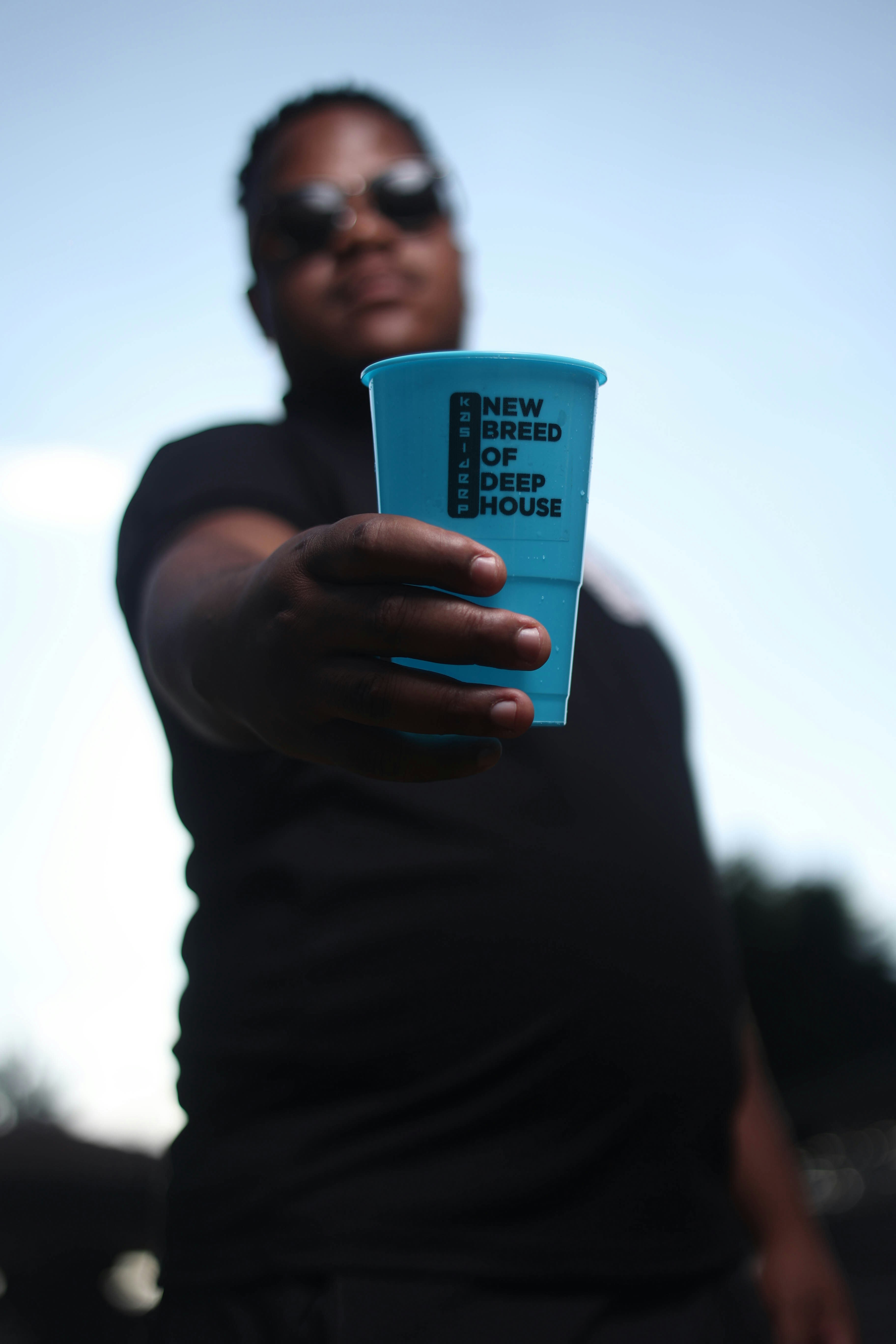 Blue Cup Protrudes Toward the Lens: A Hand-Forward Moment