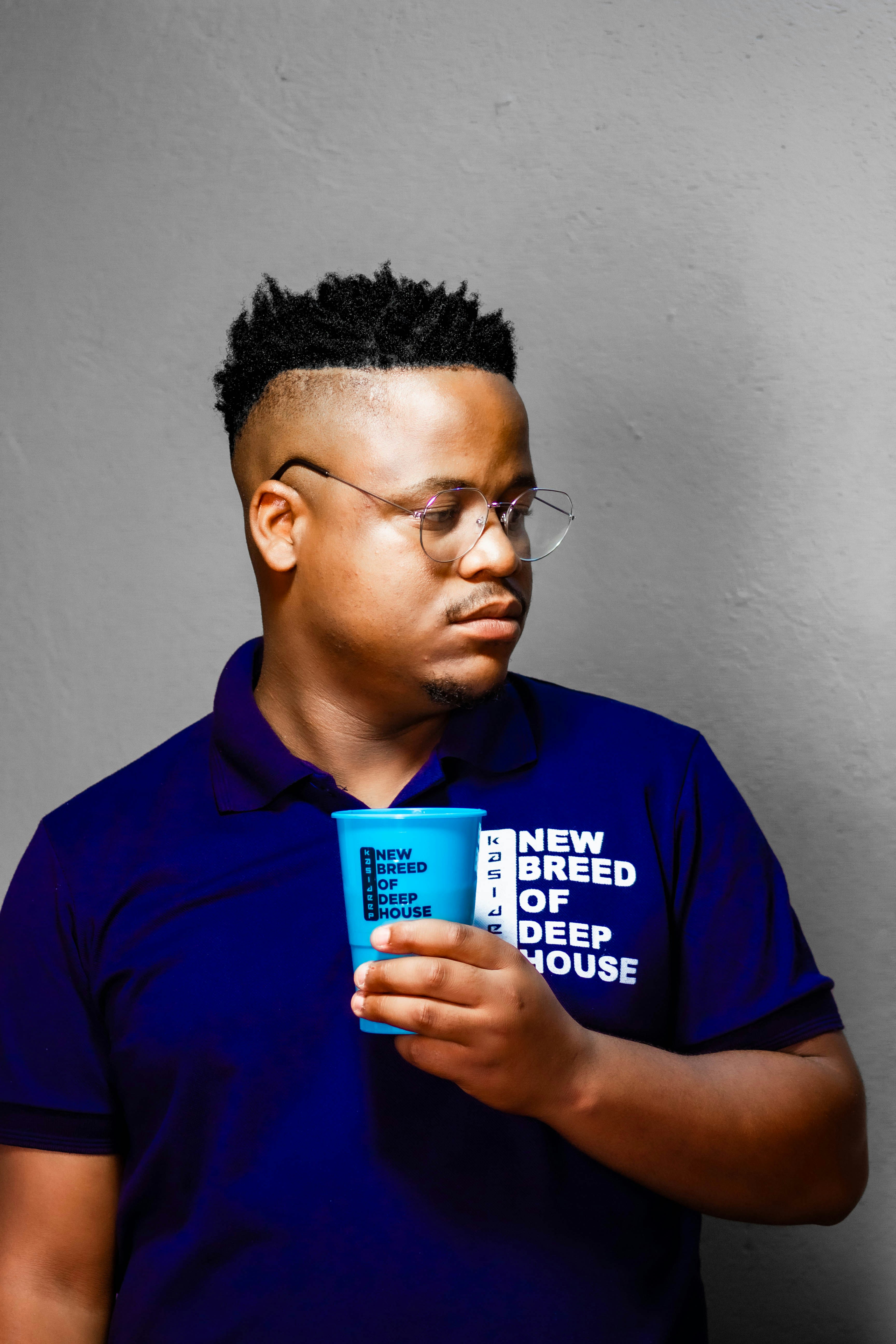 Blue Cup, Quiet Confidence: A Studio Portrait in Monochrome Backdrop