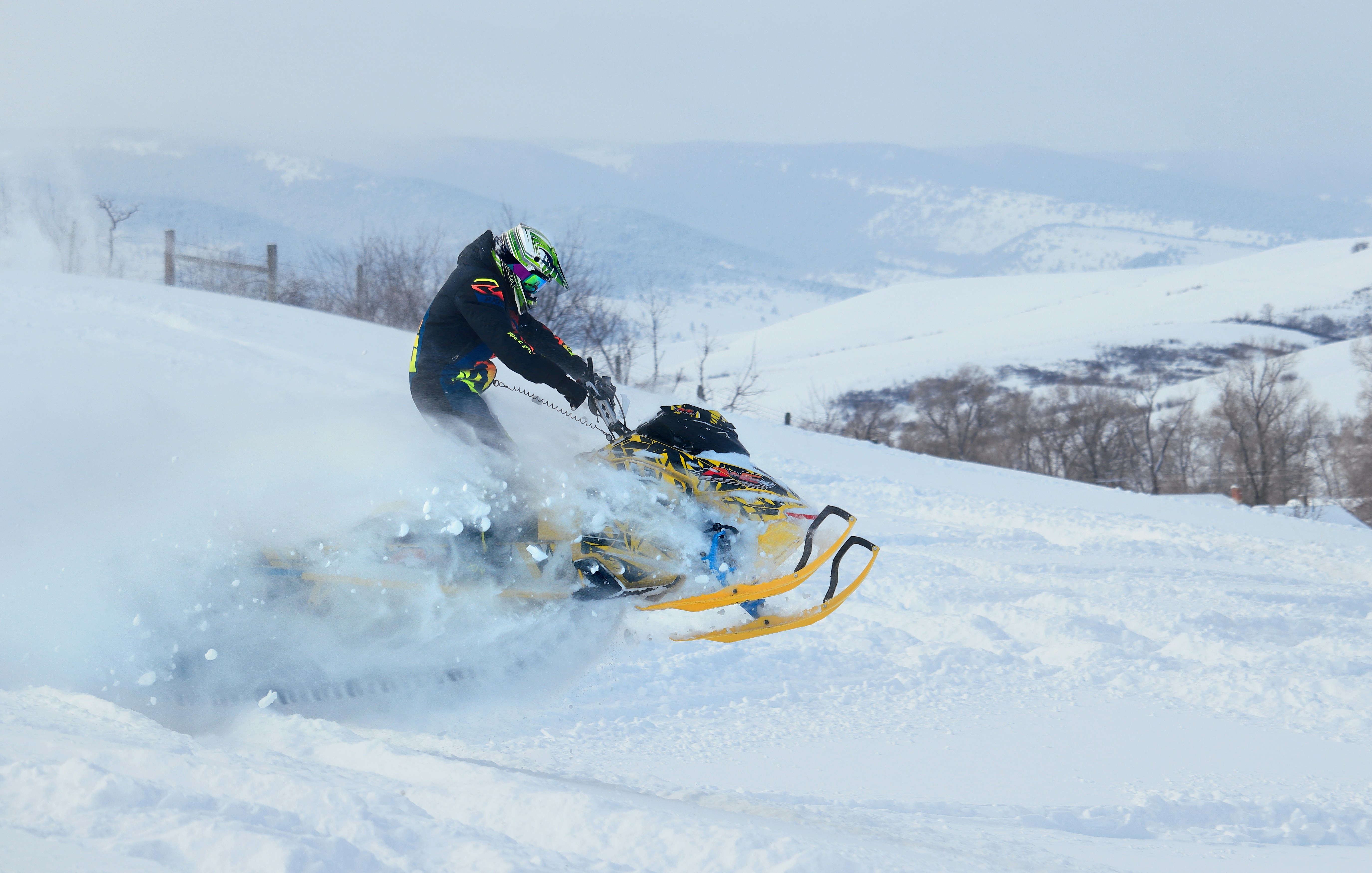 A man riding a snowmobile down a snow covered slope photo – Free ...