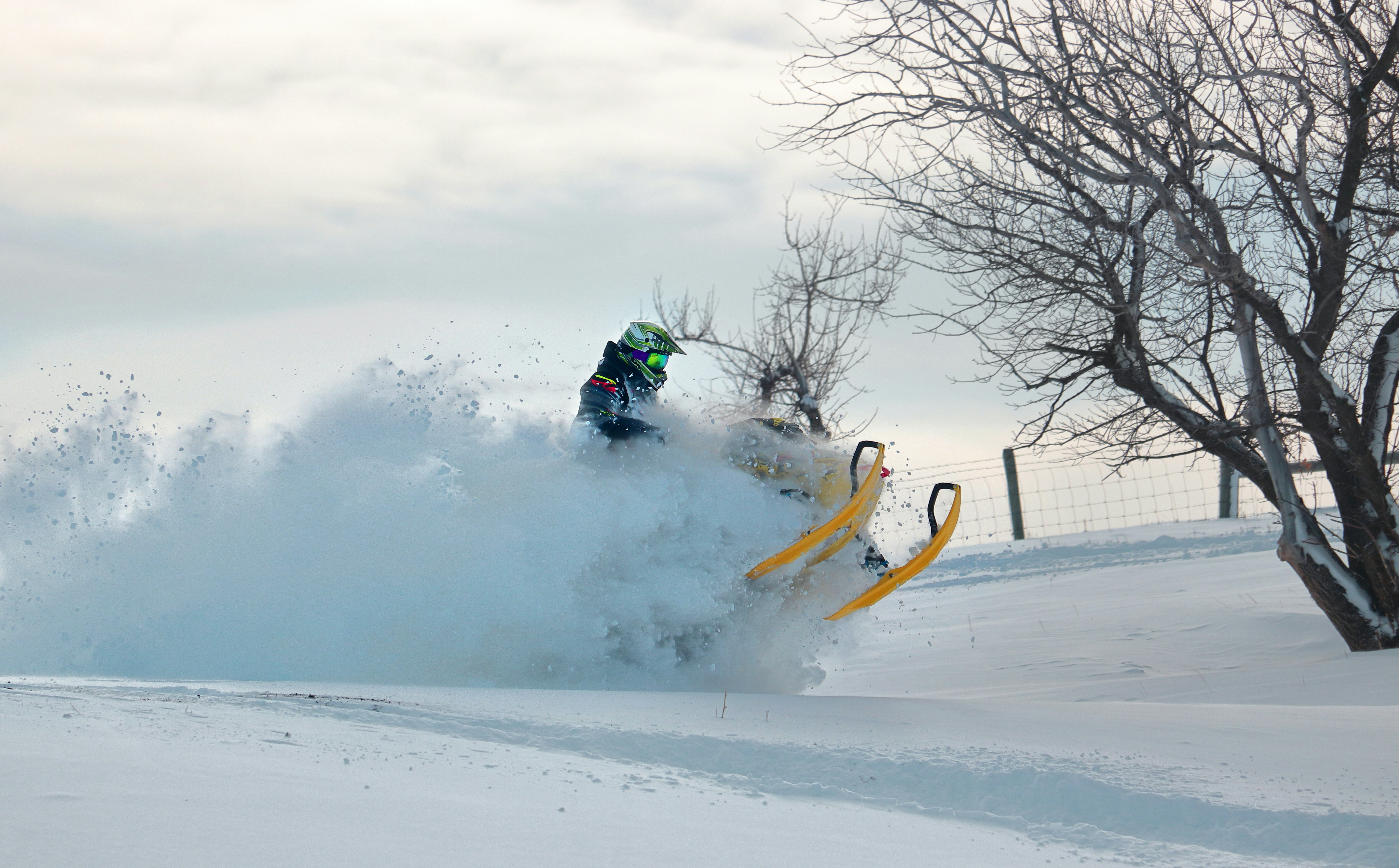 A man riding a snowmobile down a snow covered slope photo – Free Grey ...