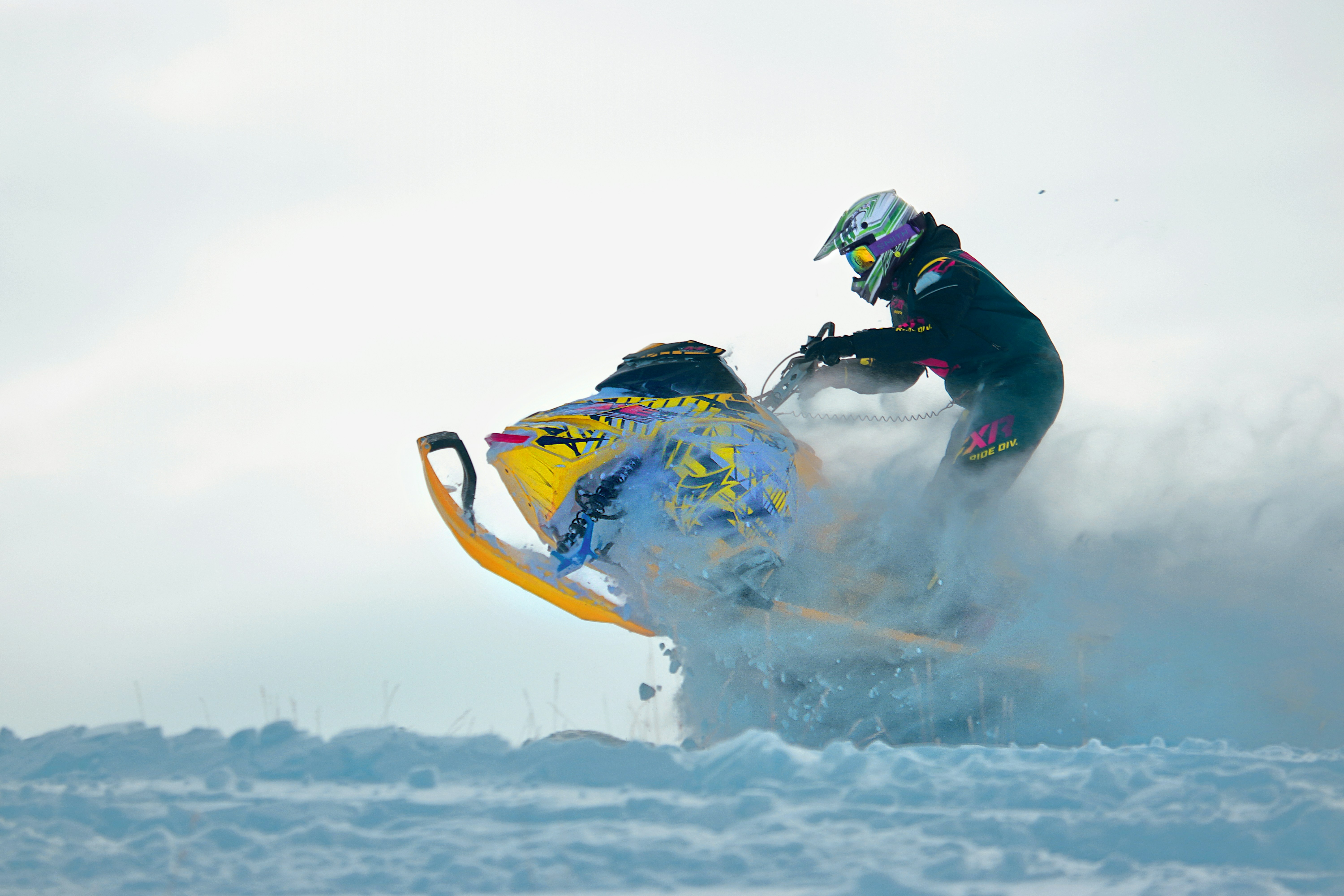 A man riding a snowmobile on top of a snow covered slope photo – Free ...