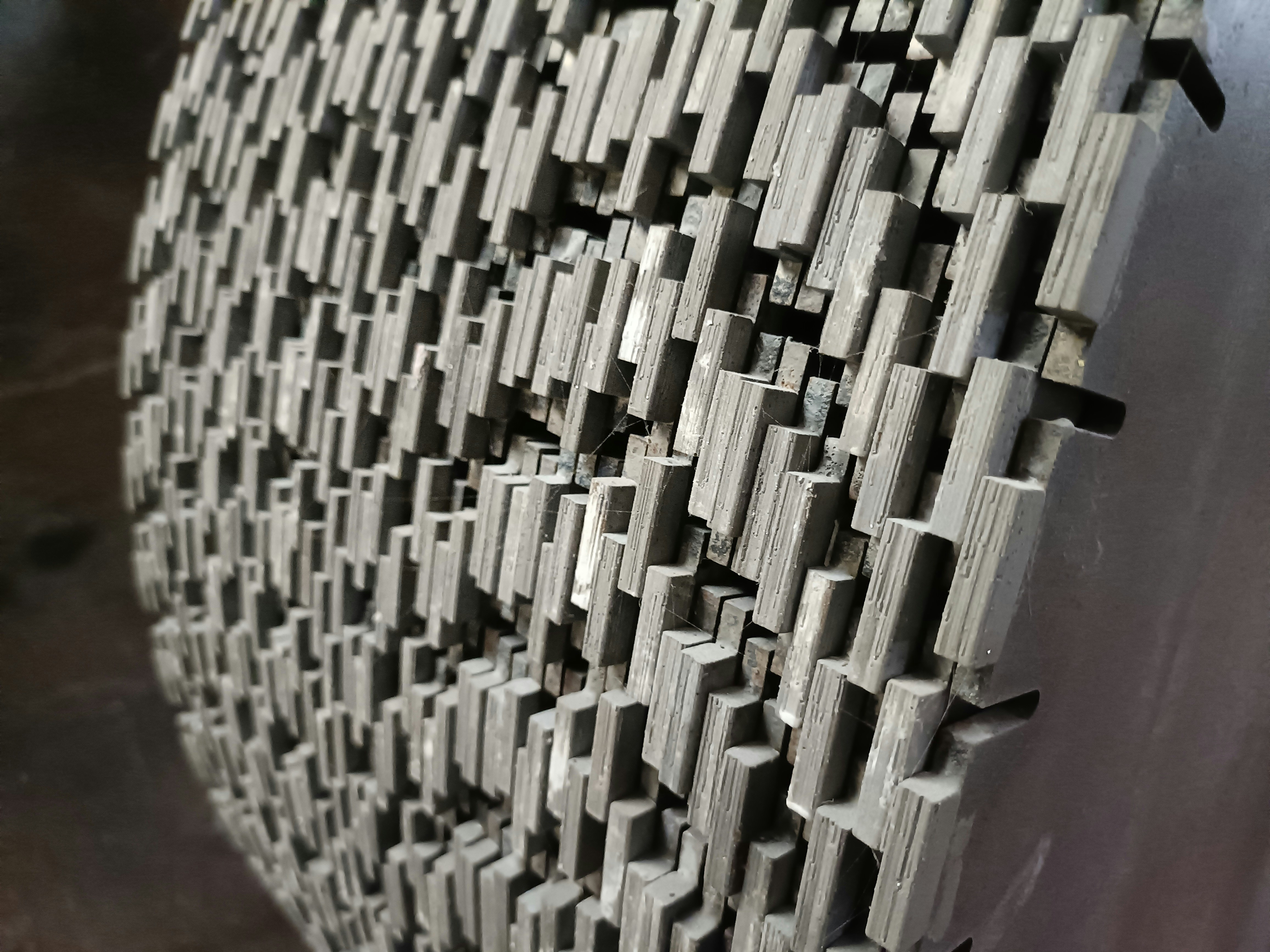 Close-up view of a uniquely textured surface featuring an intricate arrangement of geometric shapes. The design showcases the interplay of light and shadow.