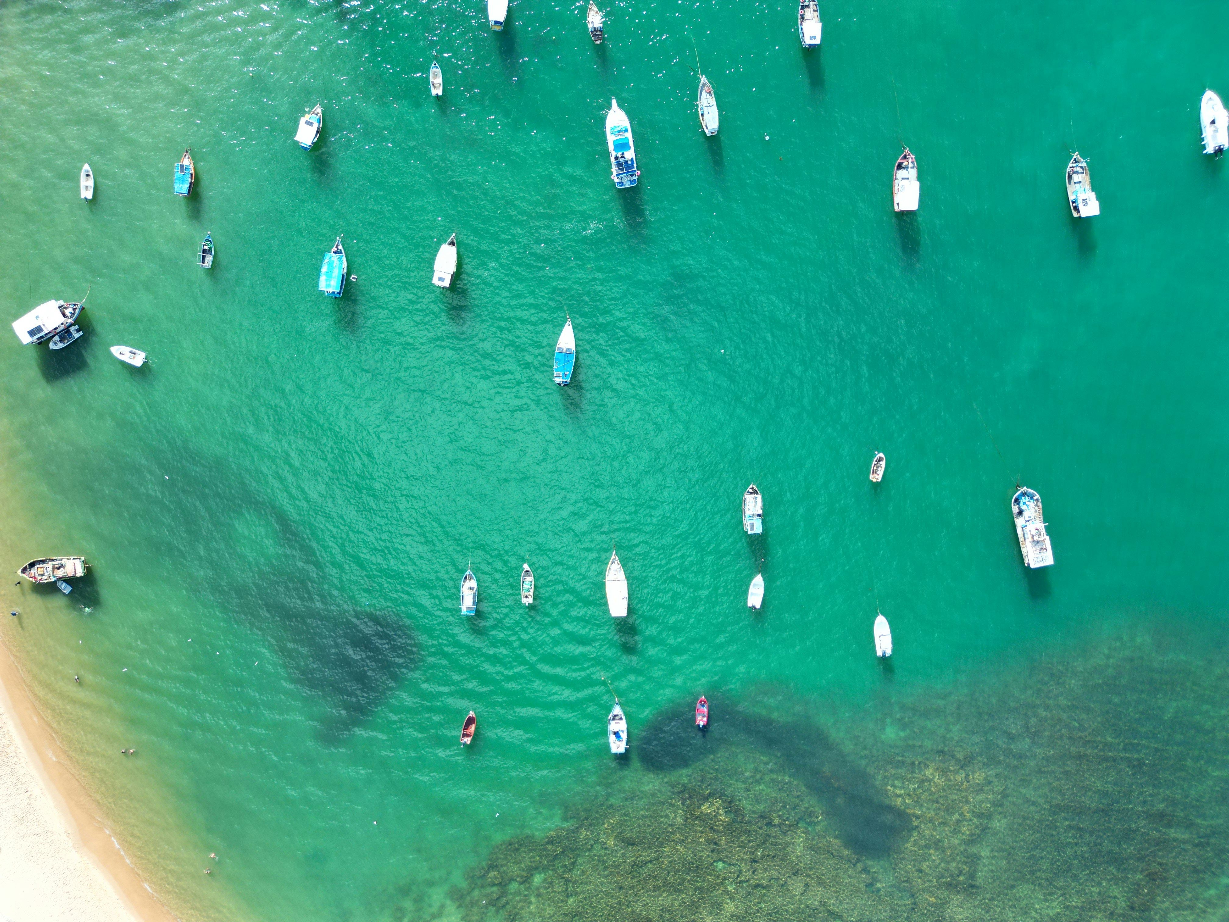 A group of boats floating on top of a body of water photo – Free Praia ...