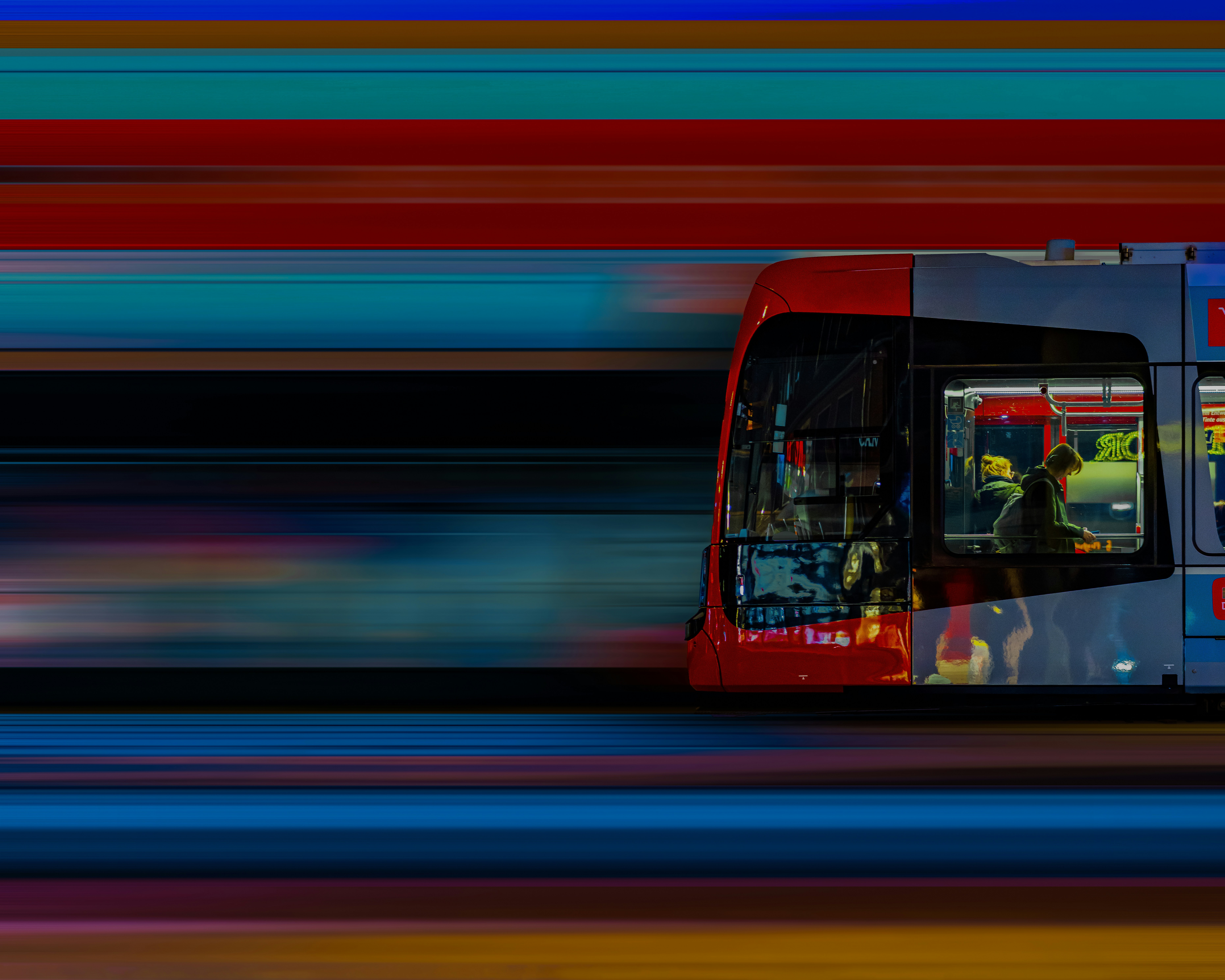 A red and blue bus traveling down a street photo – Free X Image on Unsplash