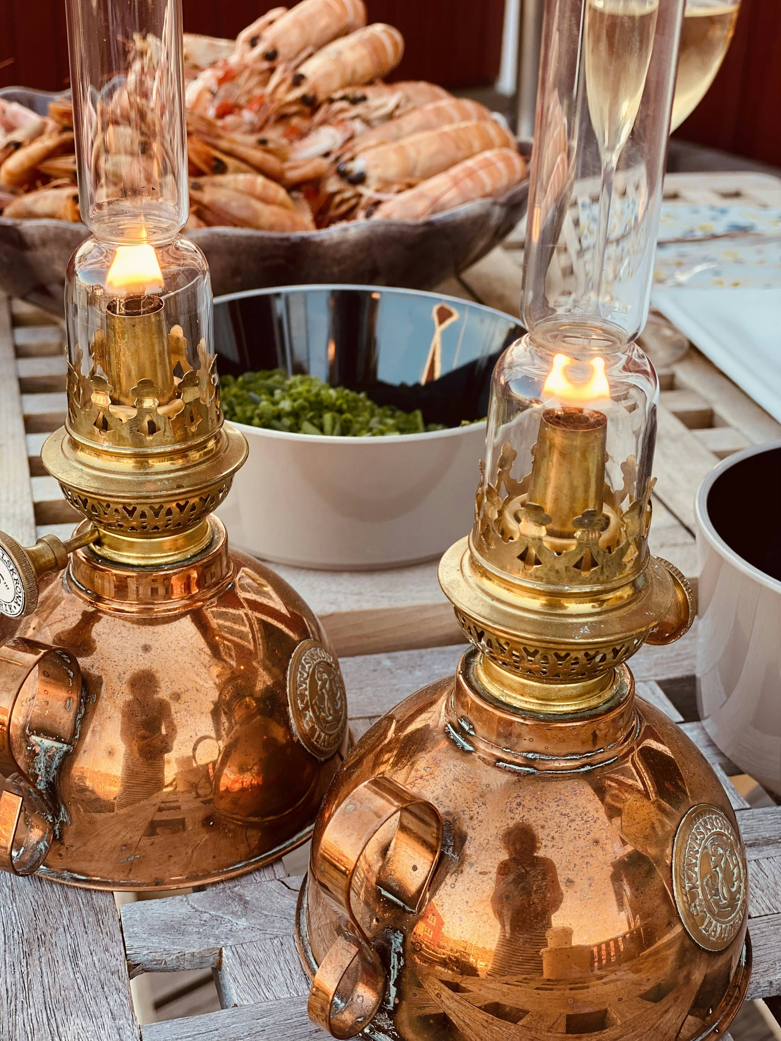 Copper Lamps Casting Warm Light Over a Shrimp Feast on a Rustic Planked Table