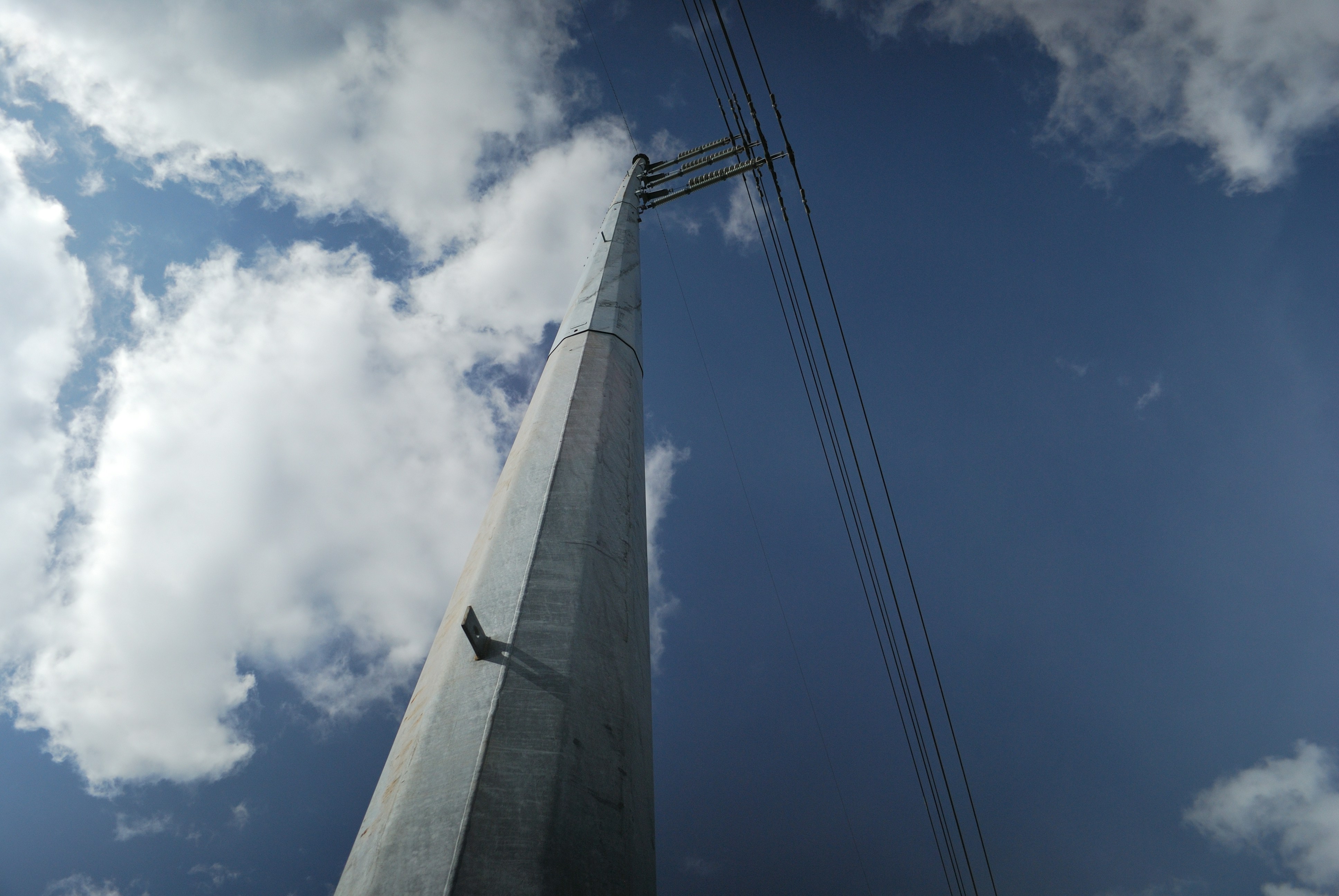 Vertical Vector: Low-Angle Portrait of a Power Mast Against Sky