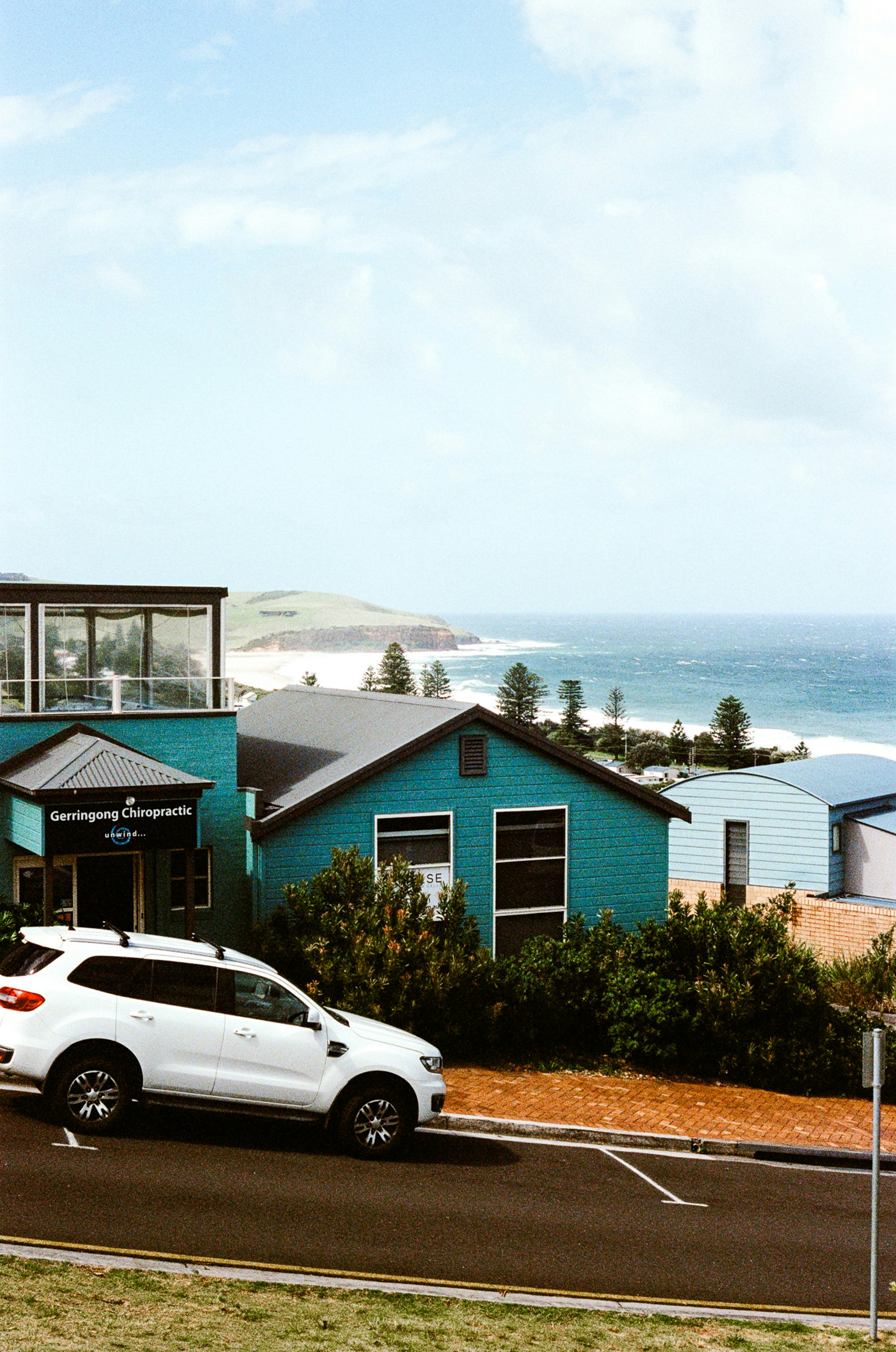 A white car parked in front of a blue building photo – Free Car Image ...