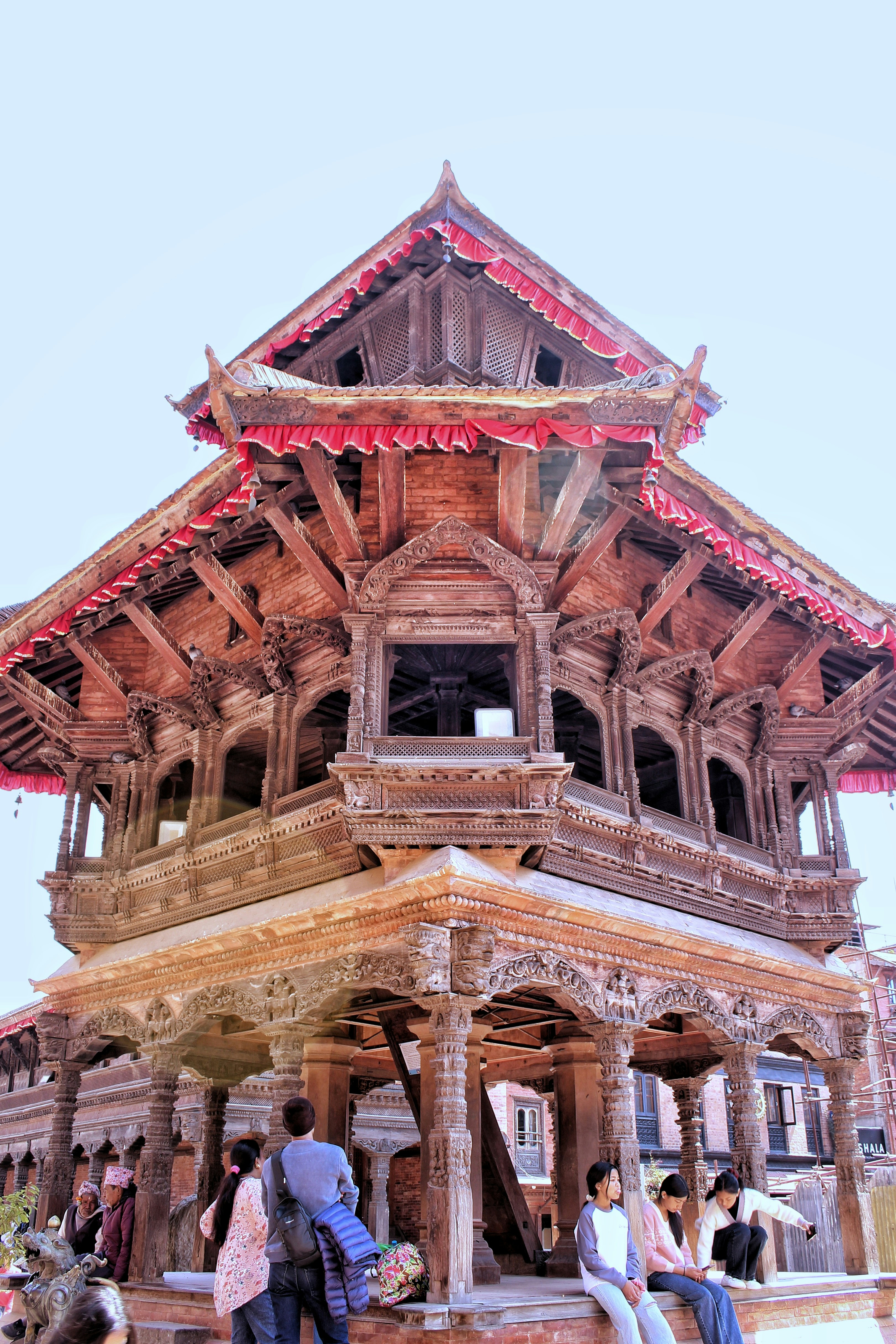 A group of people standing around a wooden structure photo – Free ...
