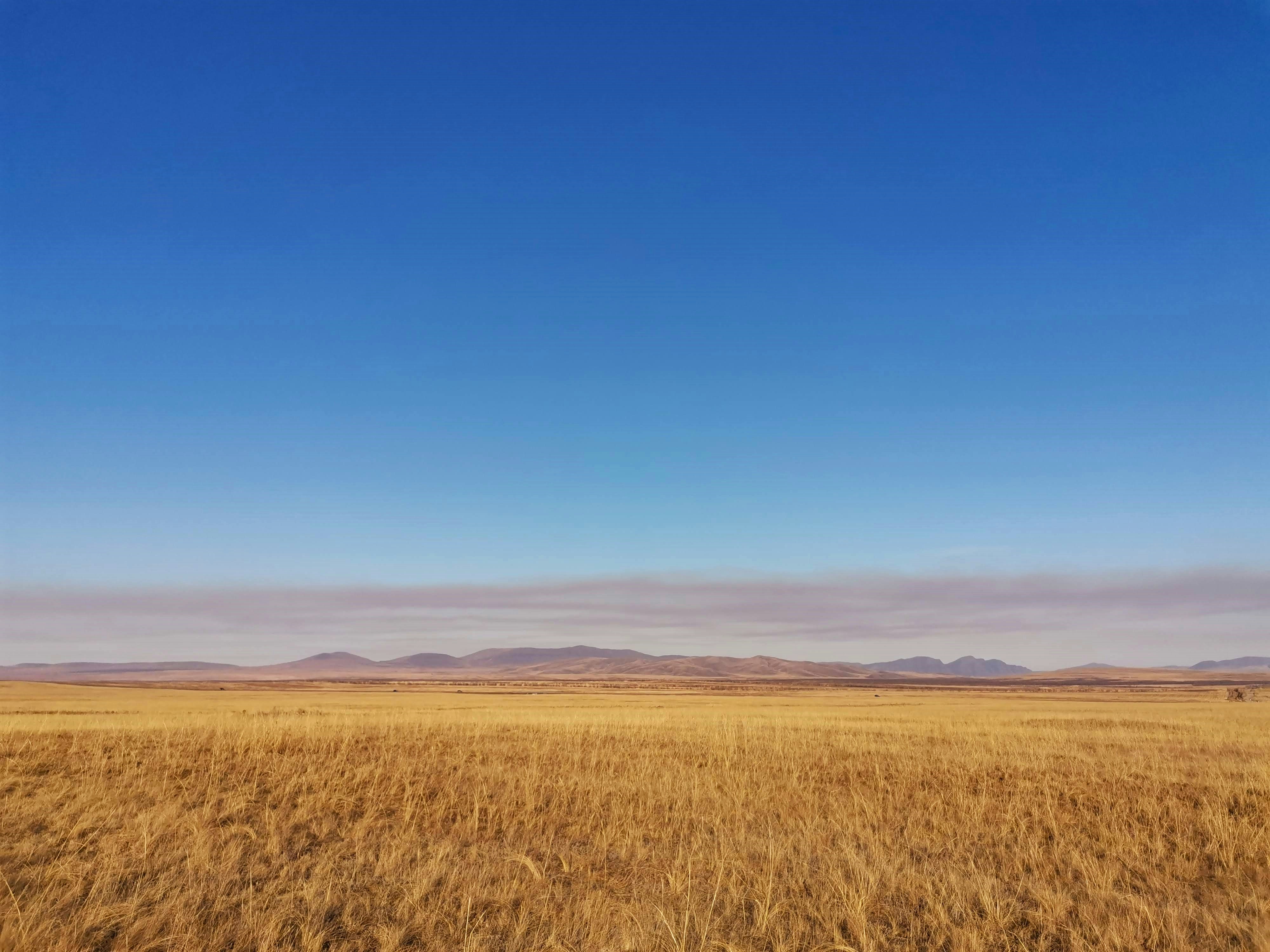 A large open field with mountains in the distance photo – Free ...