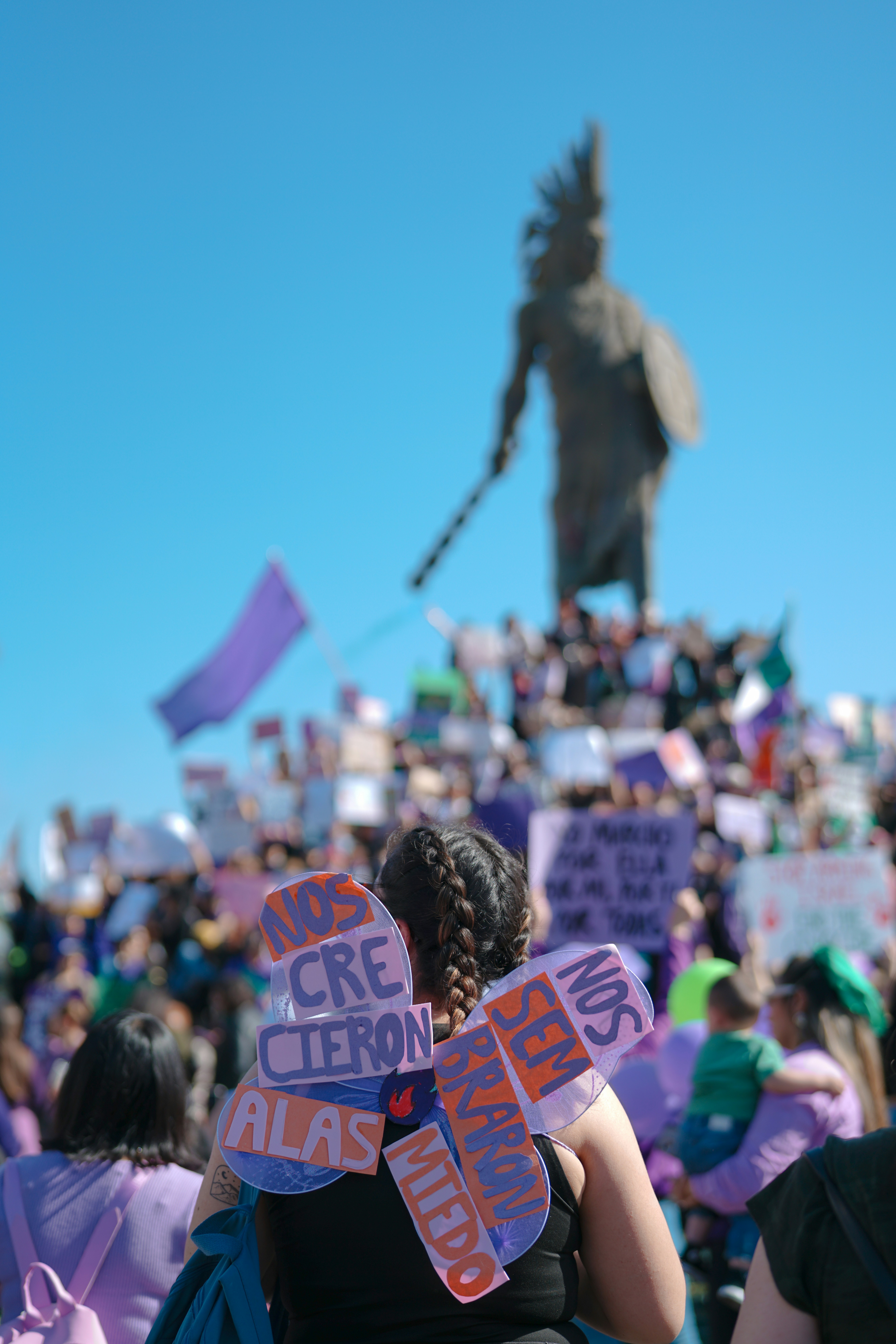 A group of people holding signs in front of a statue photo – Free Blue ...