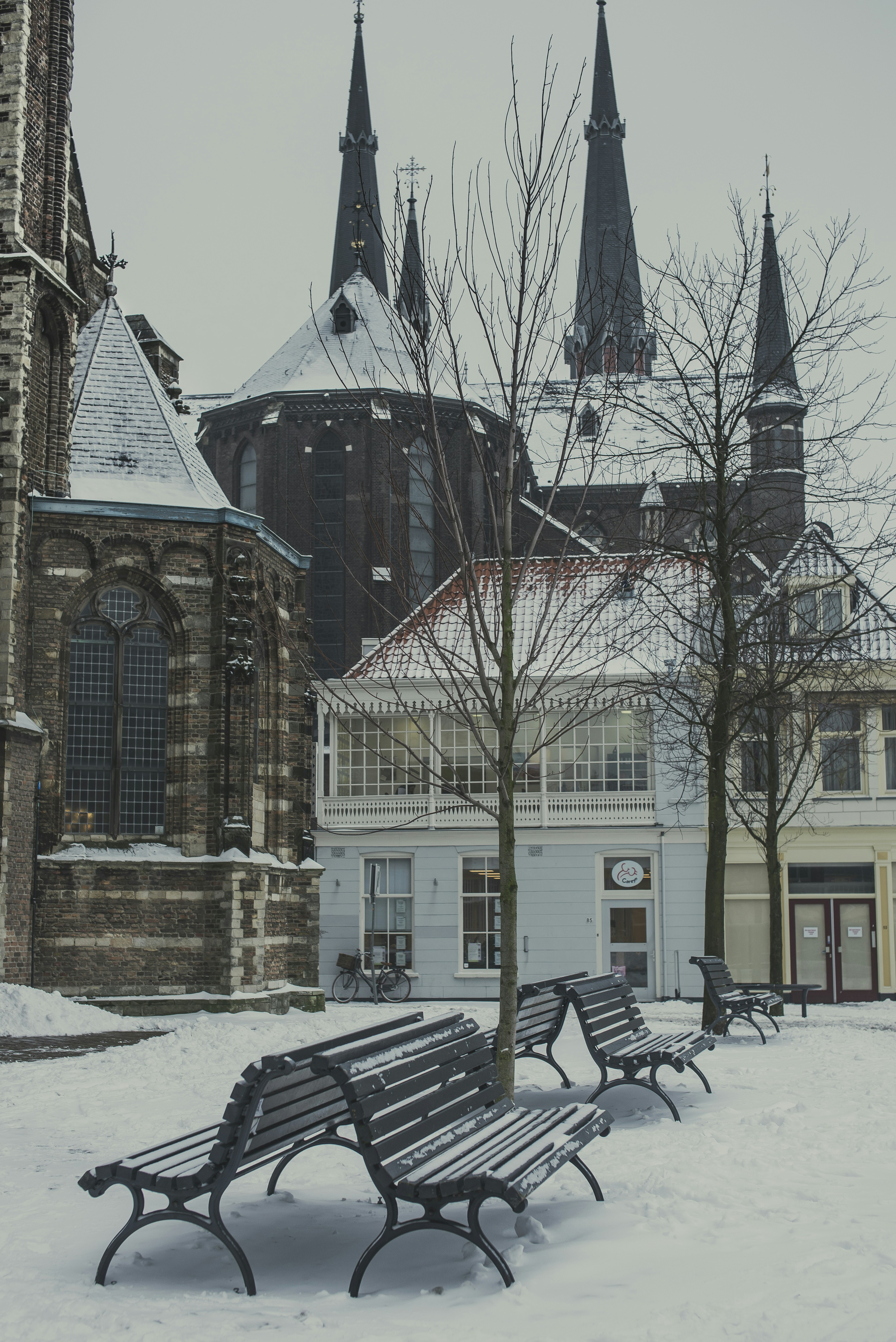 Winter Silence at the Bench-Lined Plaza Framed by Snow-Capped Spires
