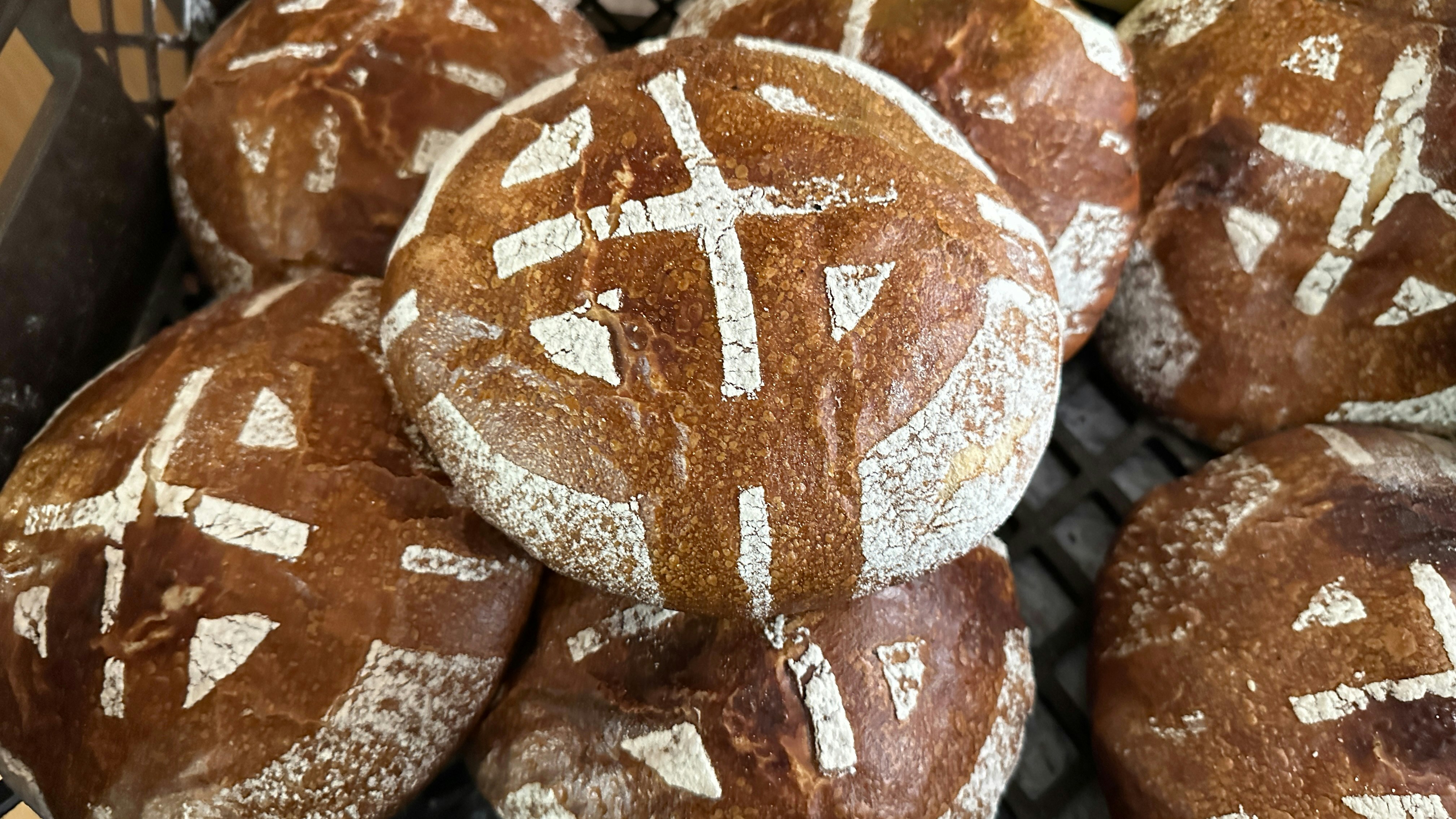 Crisscross Crusts: Flour-dusted Brioche Rounds in a Rustic Bakery Stack