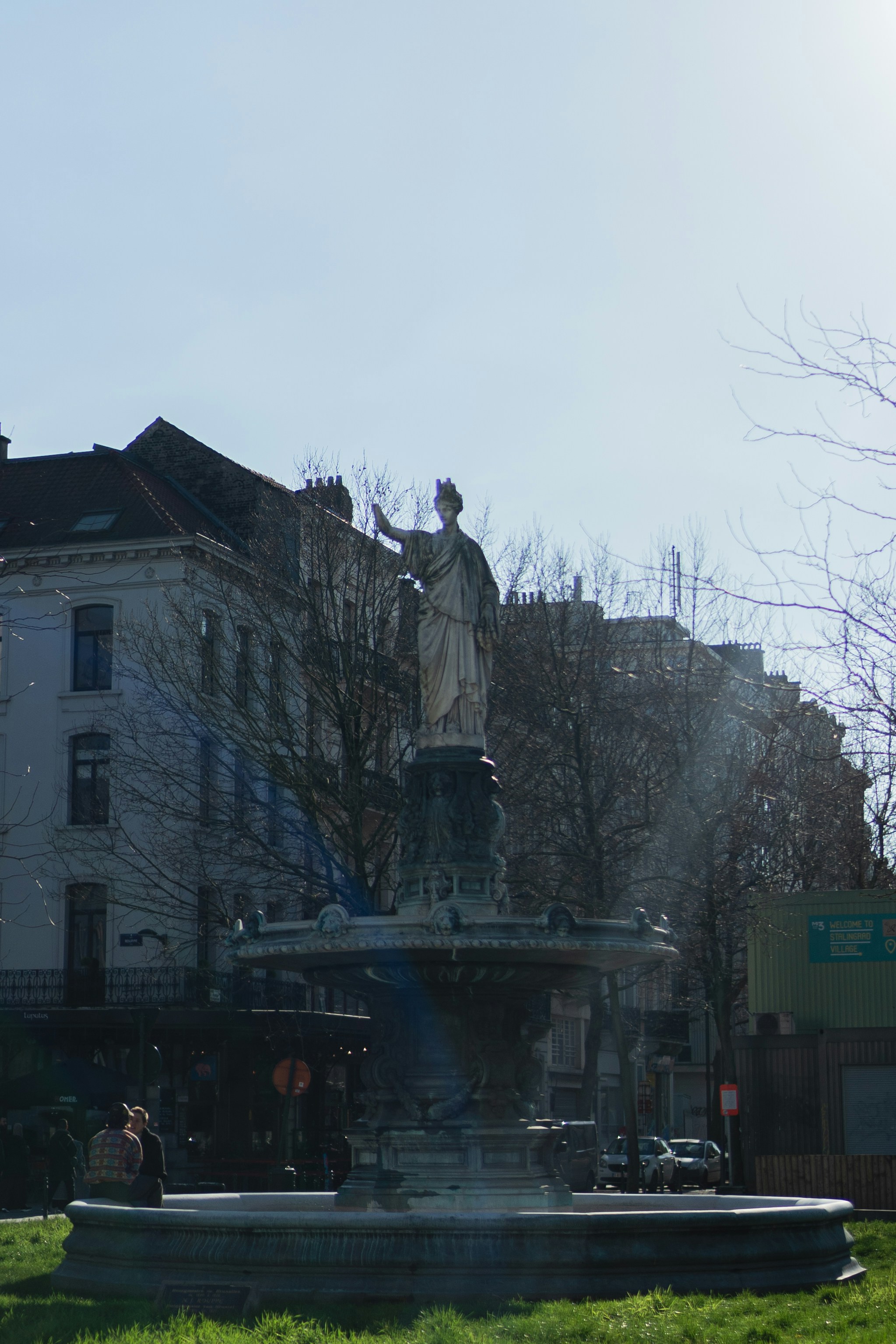 The Quiet Guardian: A statue atop a tiered fountain in a European city square
