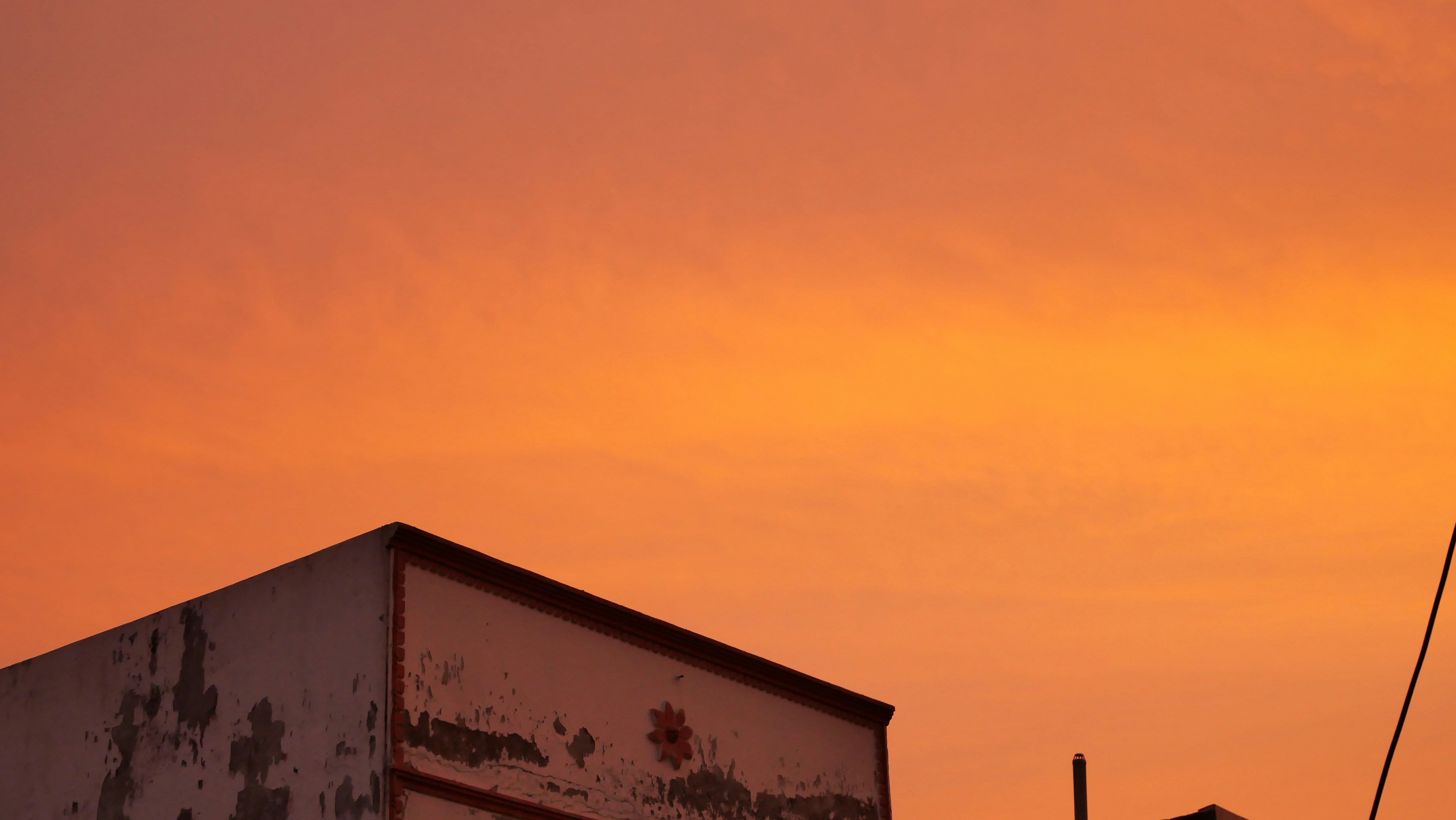 Crimson Rooftop Silhouette Beneath an Amber Dusk Sky
