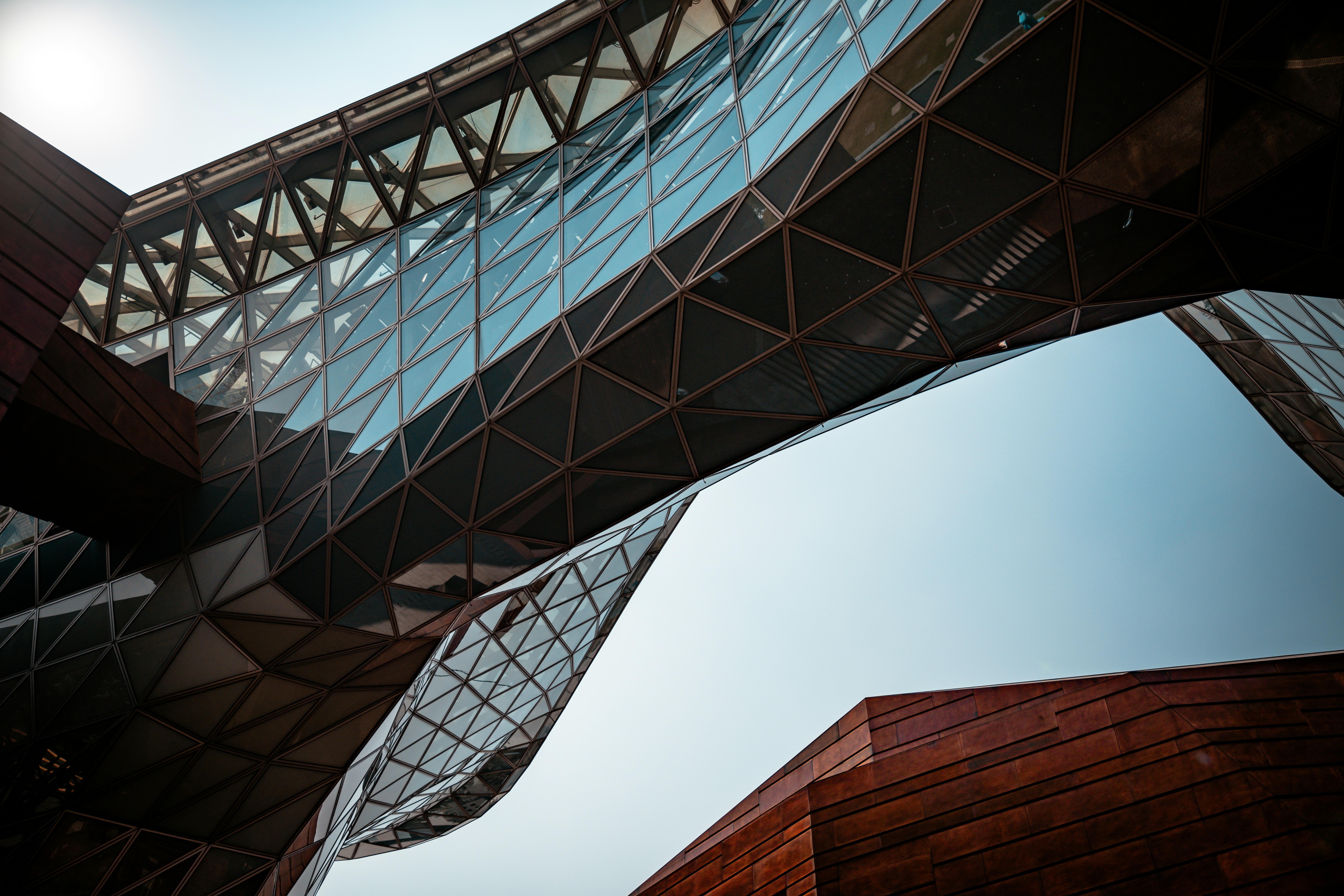 Crisscrossed Skyways: Glass Bridges Converge Above Brick and Sky