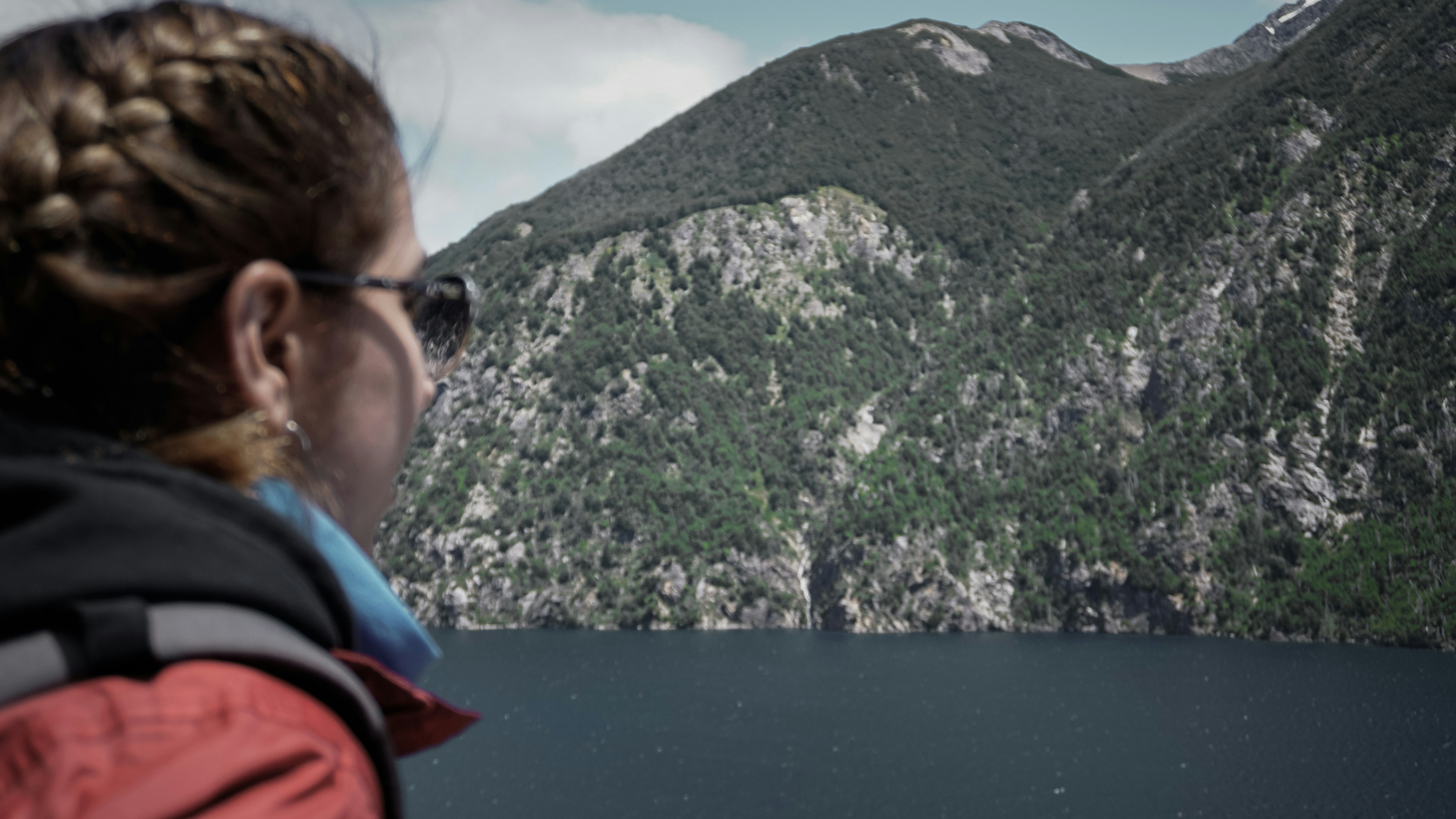 A woman looking out over a lake with mountains in the background photo ...