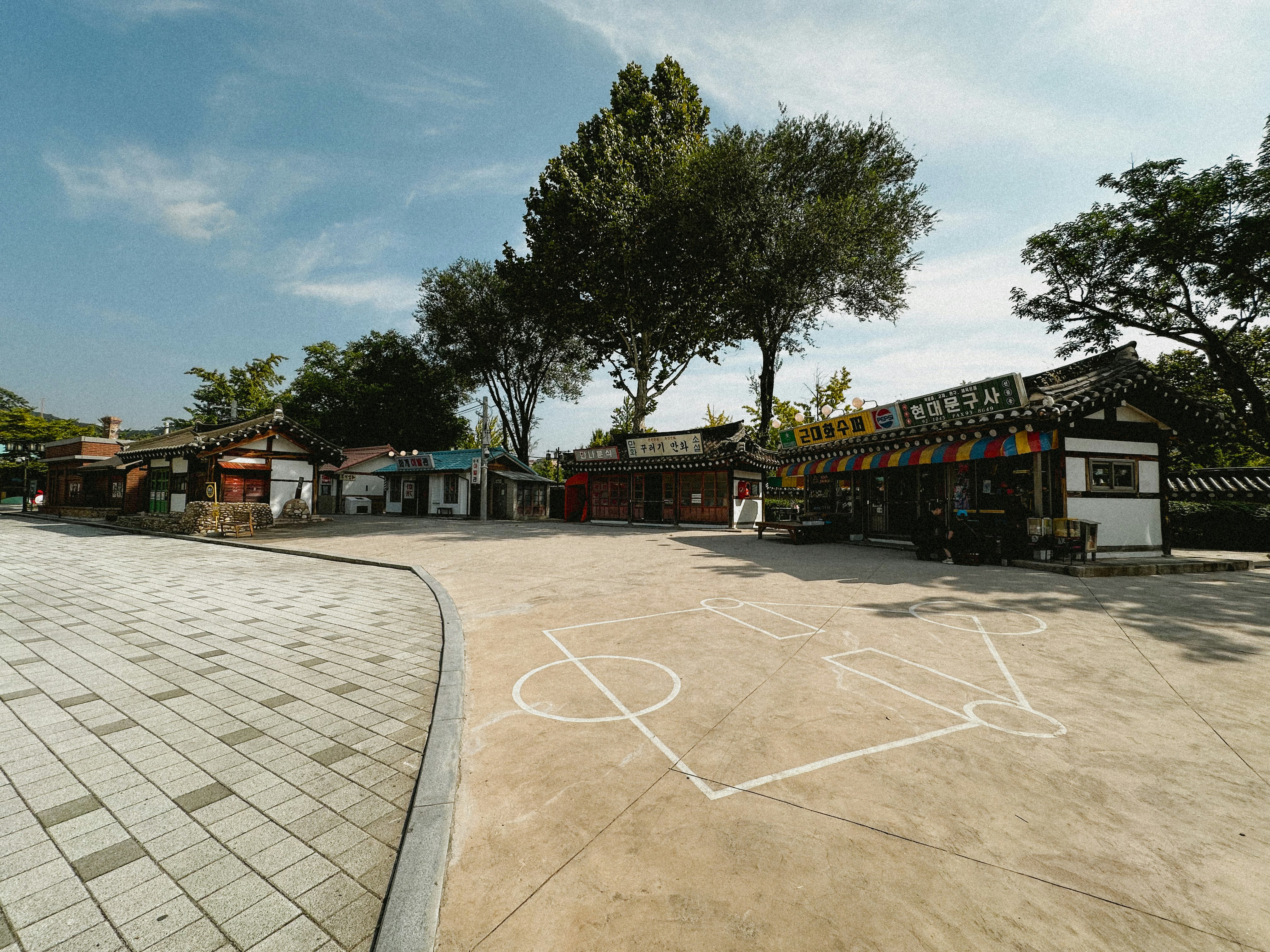 Sunlit Plaza of Painted Shops under a Quiet Sky