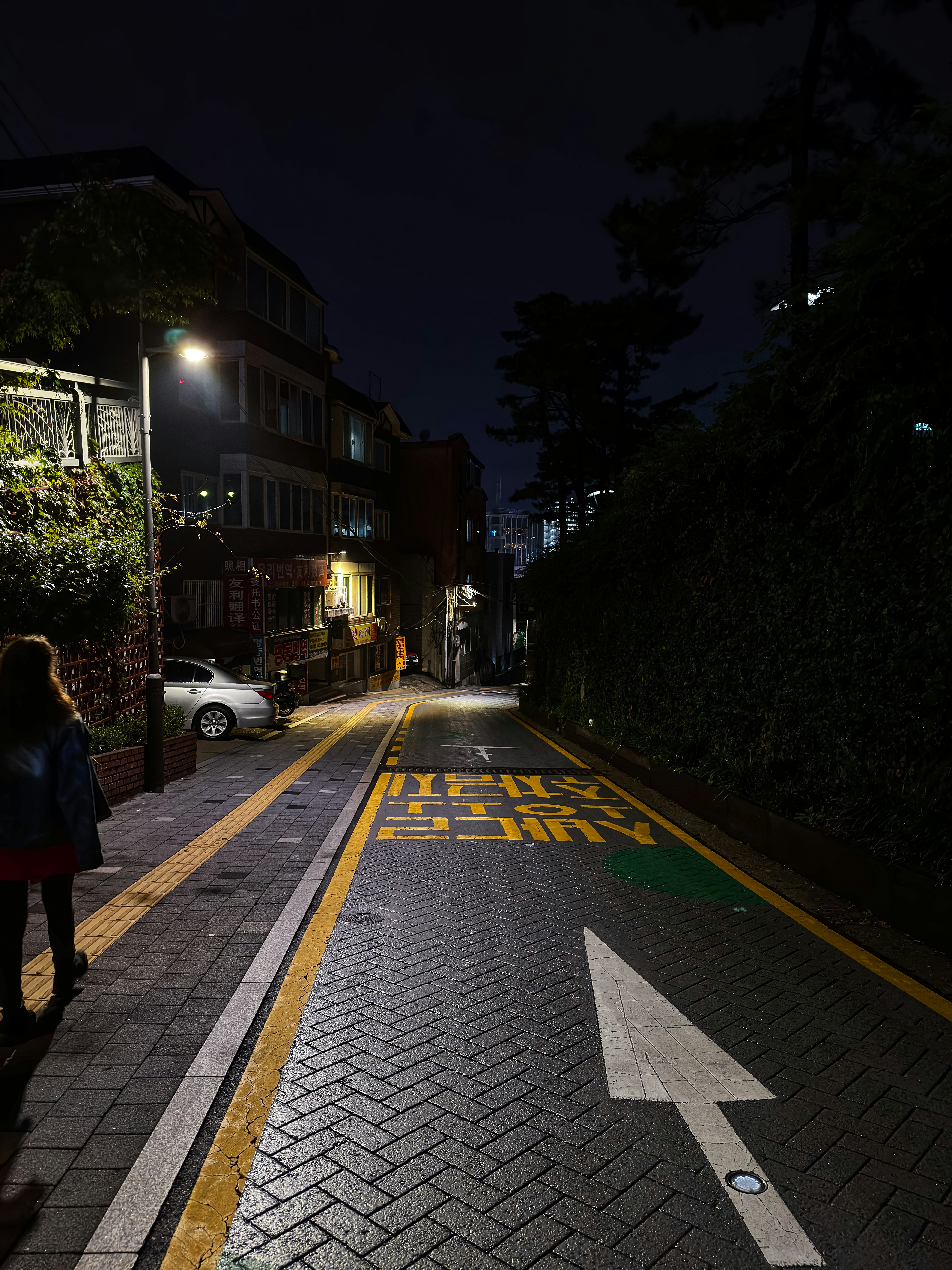 a woman walking down a street at night
