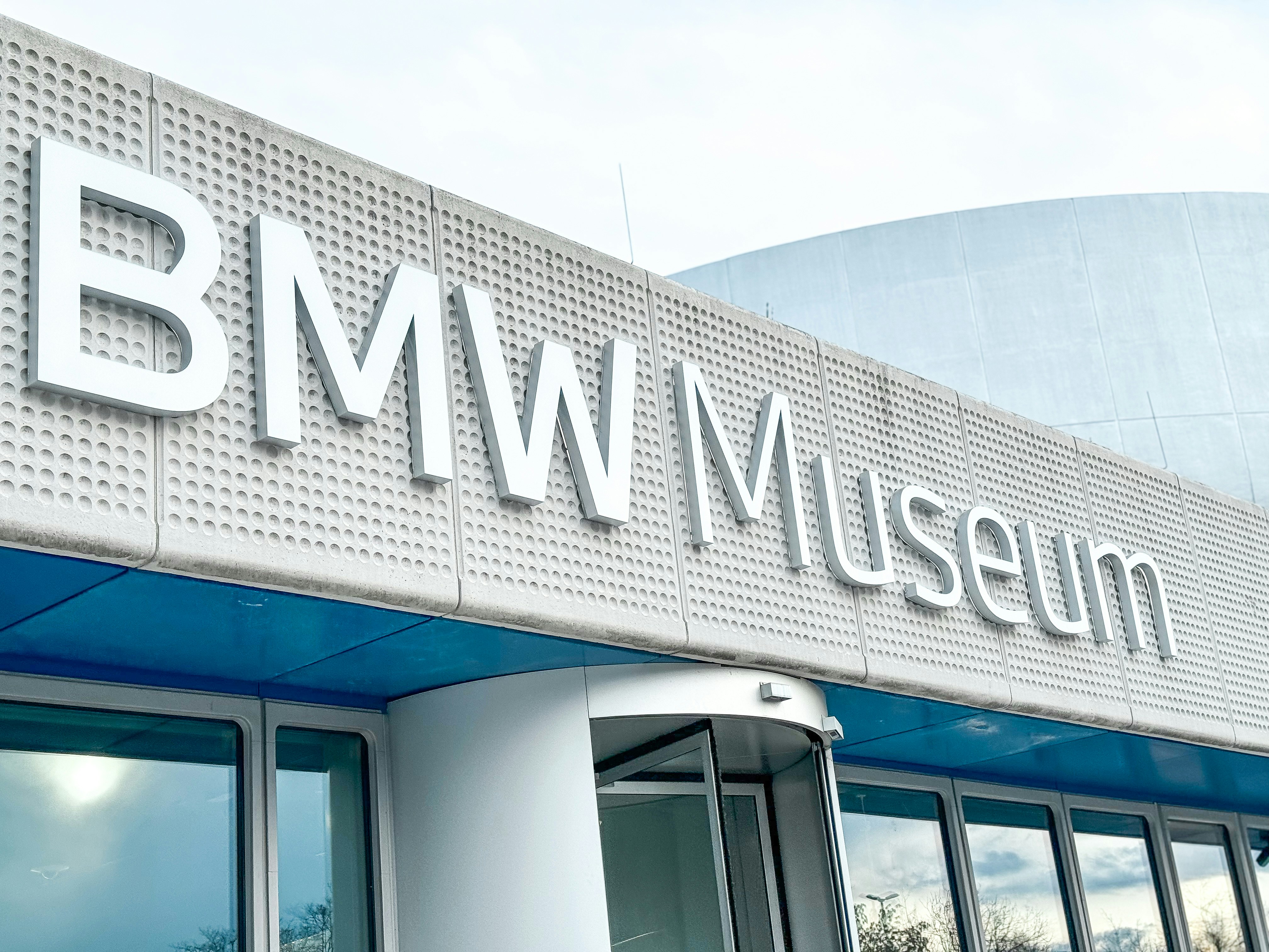 BMW Museum Facade: Perforated Metal and Glass Signage at the Entrance