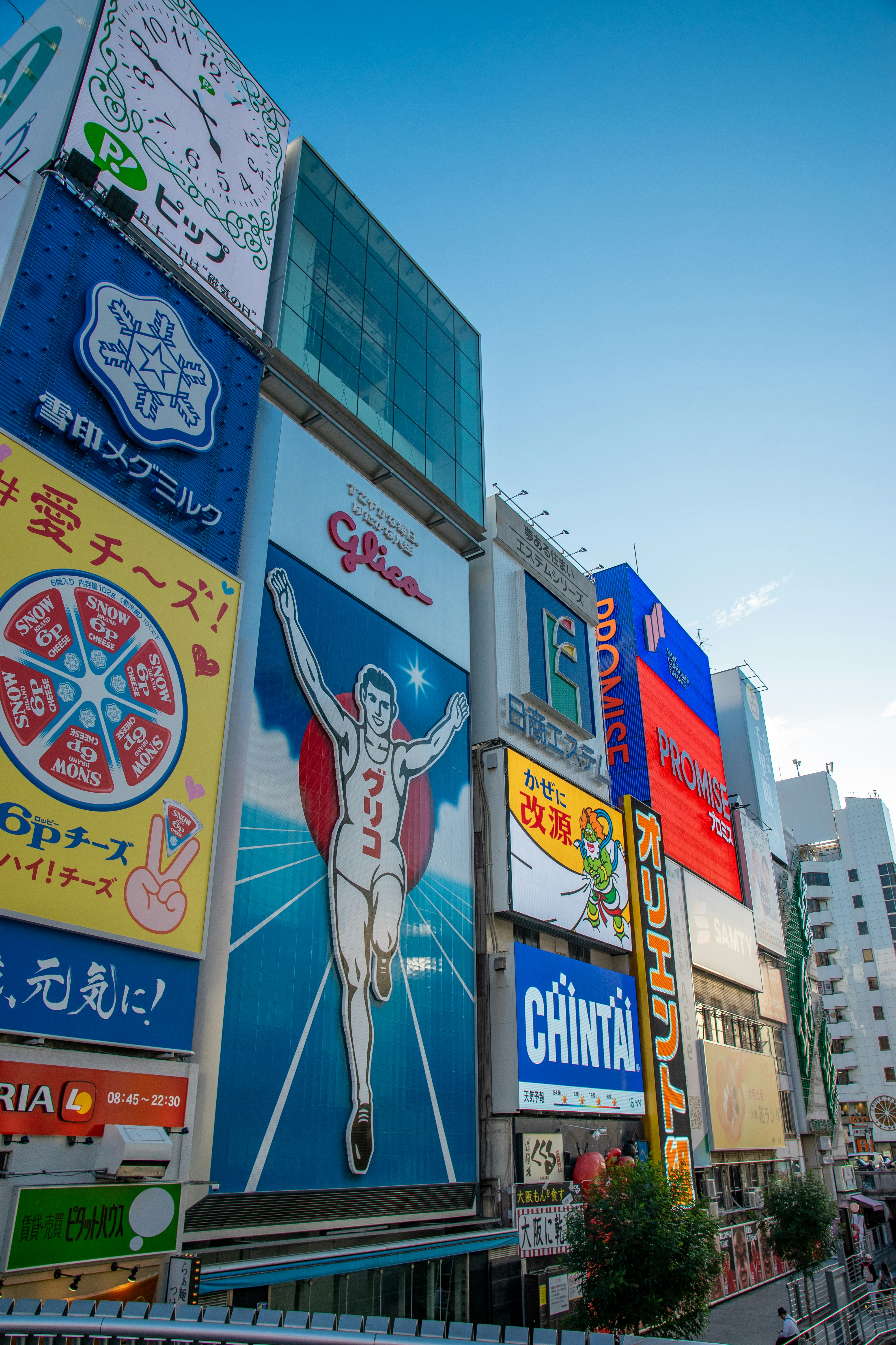 Vibrant advertisements adorn a city building, featuring a large mural of an athlete in motion, surrounded by colorful signage and branding.