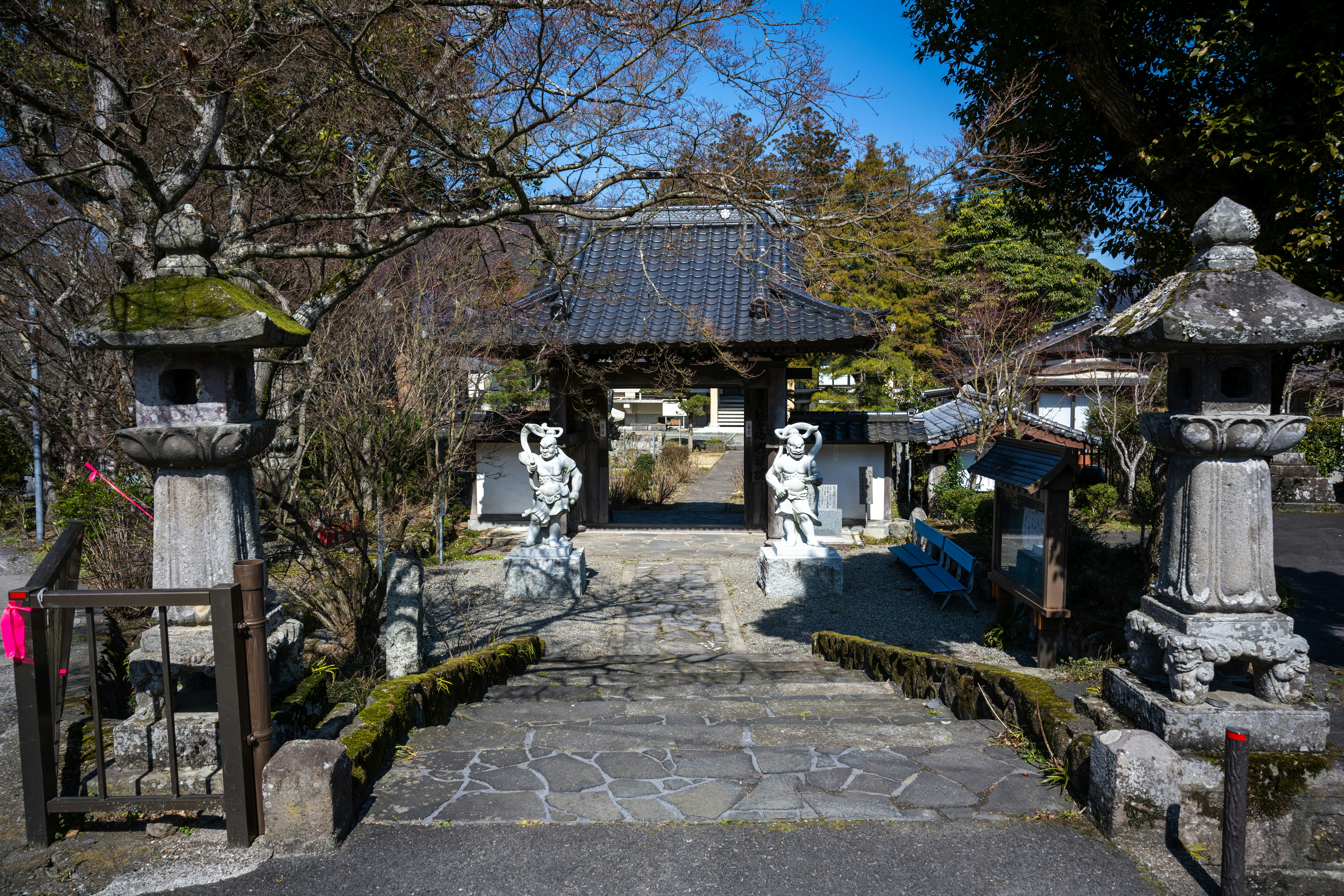 A stone path leading to a gate with statues on it photo – Free Building ...