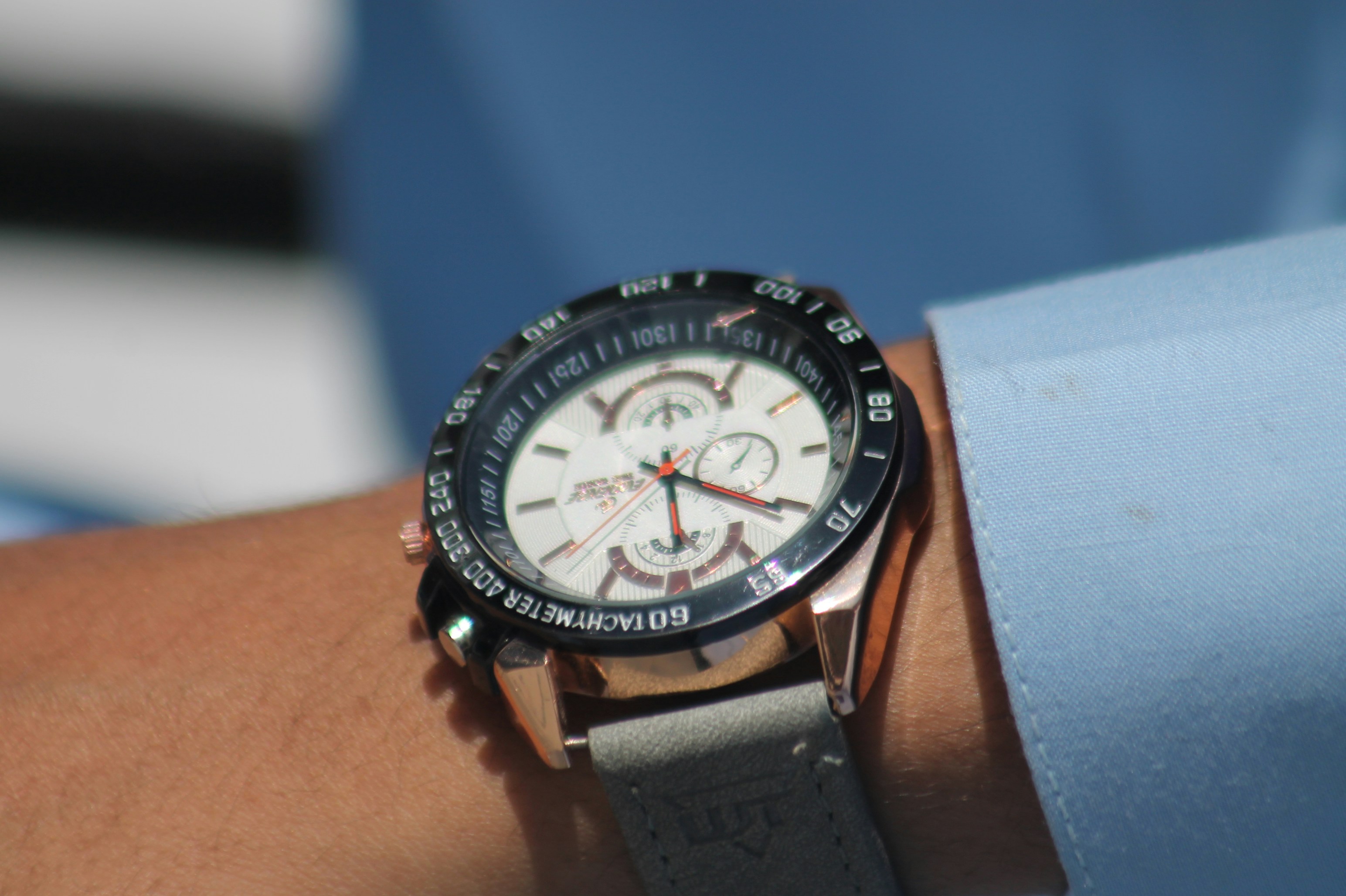 Dial in Focus: A Close-Up of a Sport Watch on a Blue-Cuffed Wrist