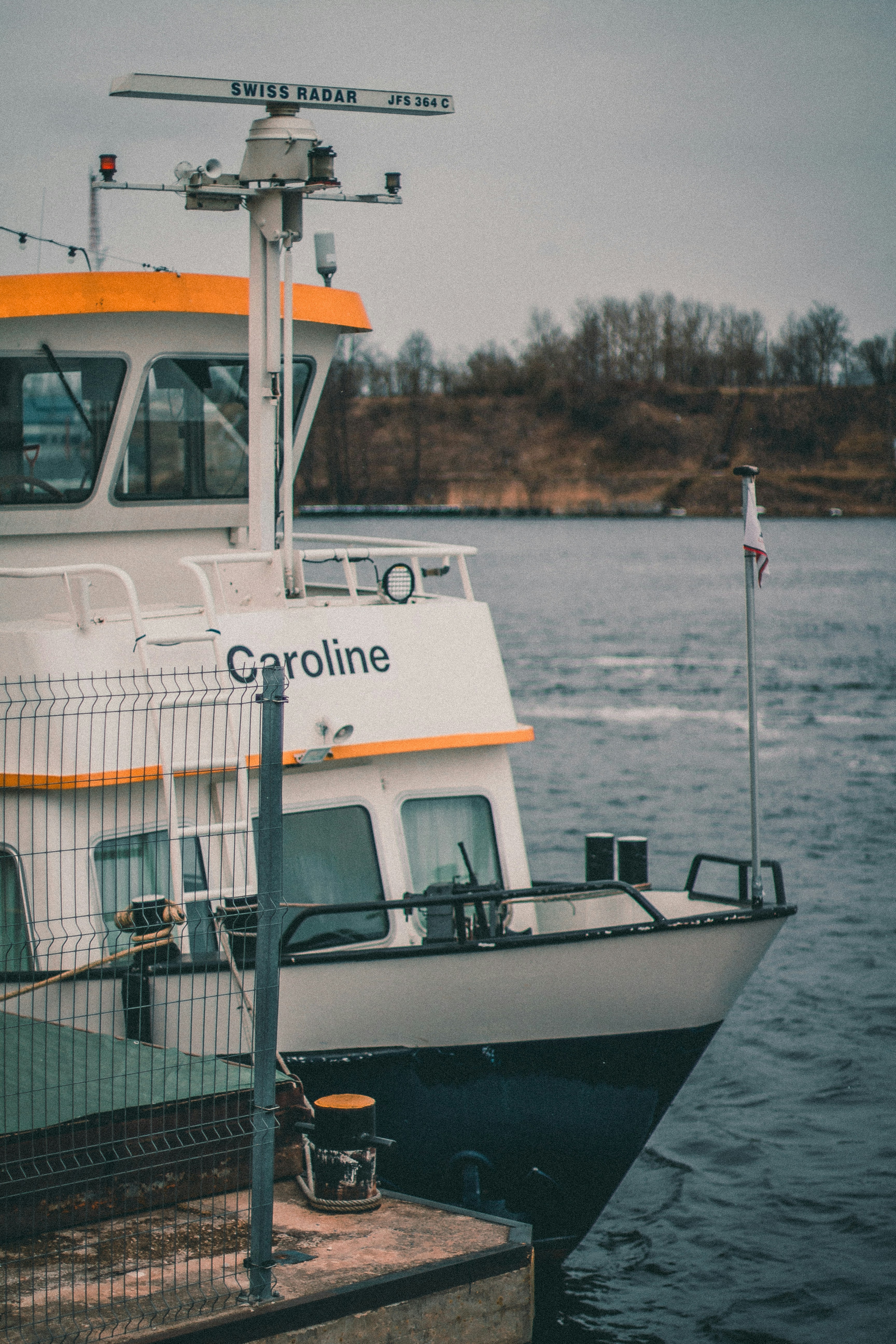Dockside Vessel: The White-Walled Boat Named Caroline Anchored by the Quay