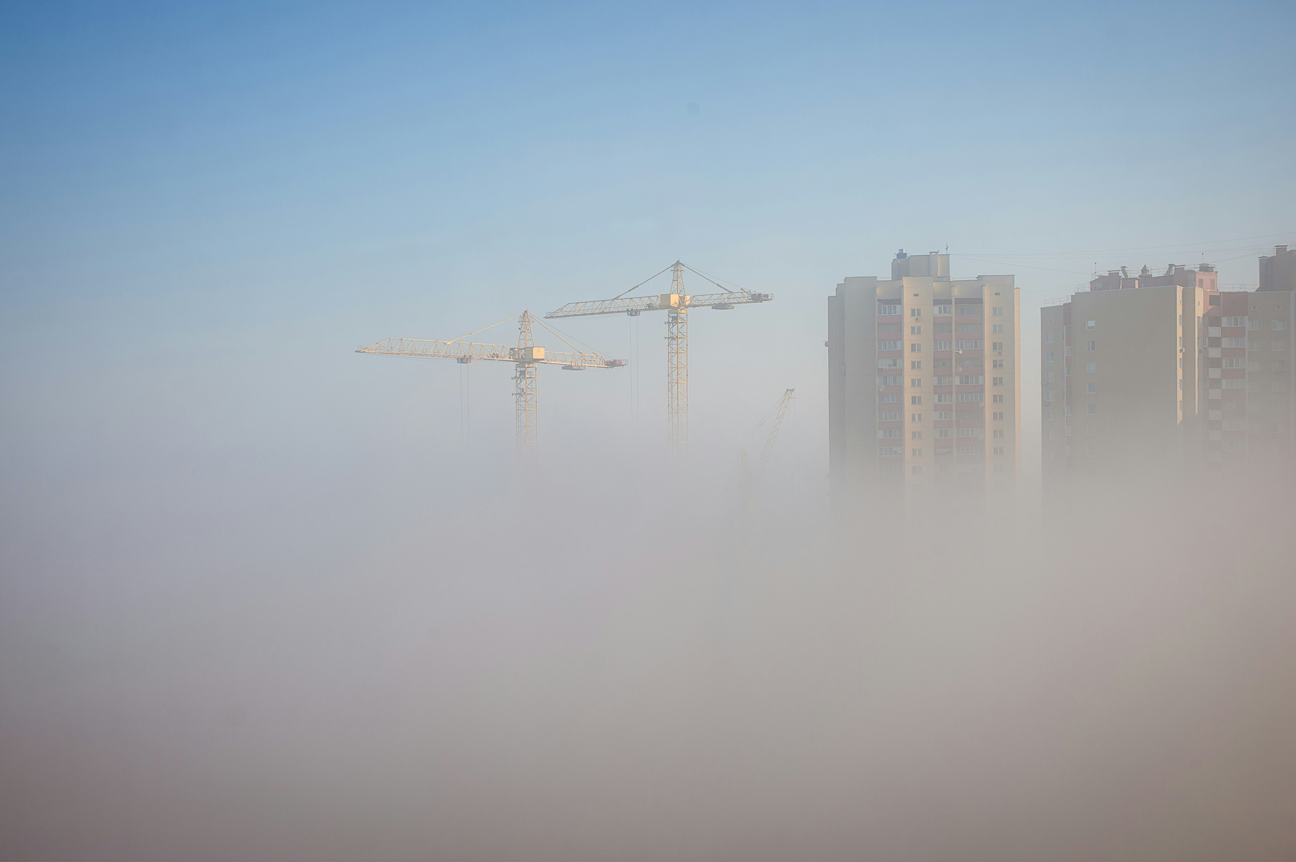 A crane is seen in the fog in a city photo – Free Kyiv Image on Unsplash