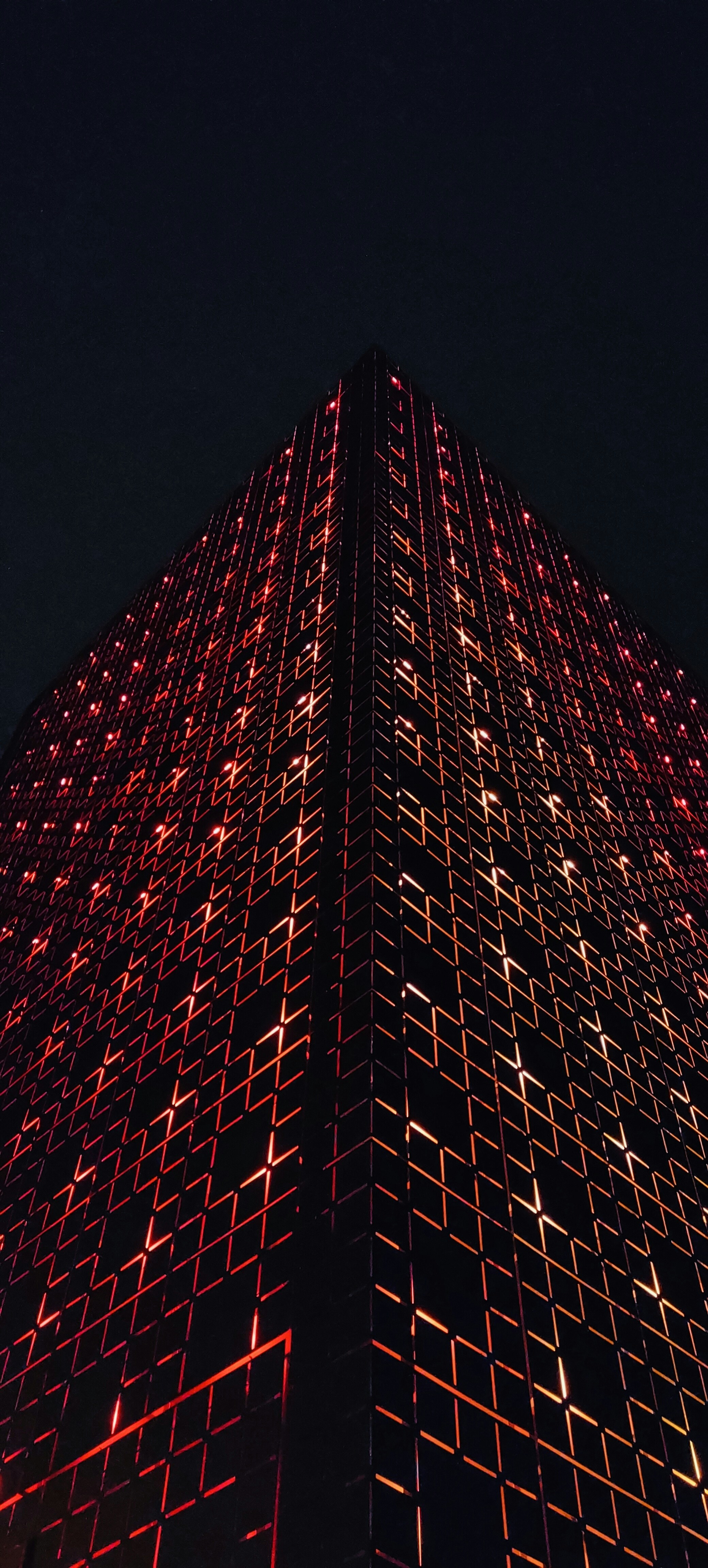 a very tall building lit up with red lights