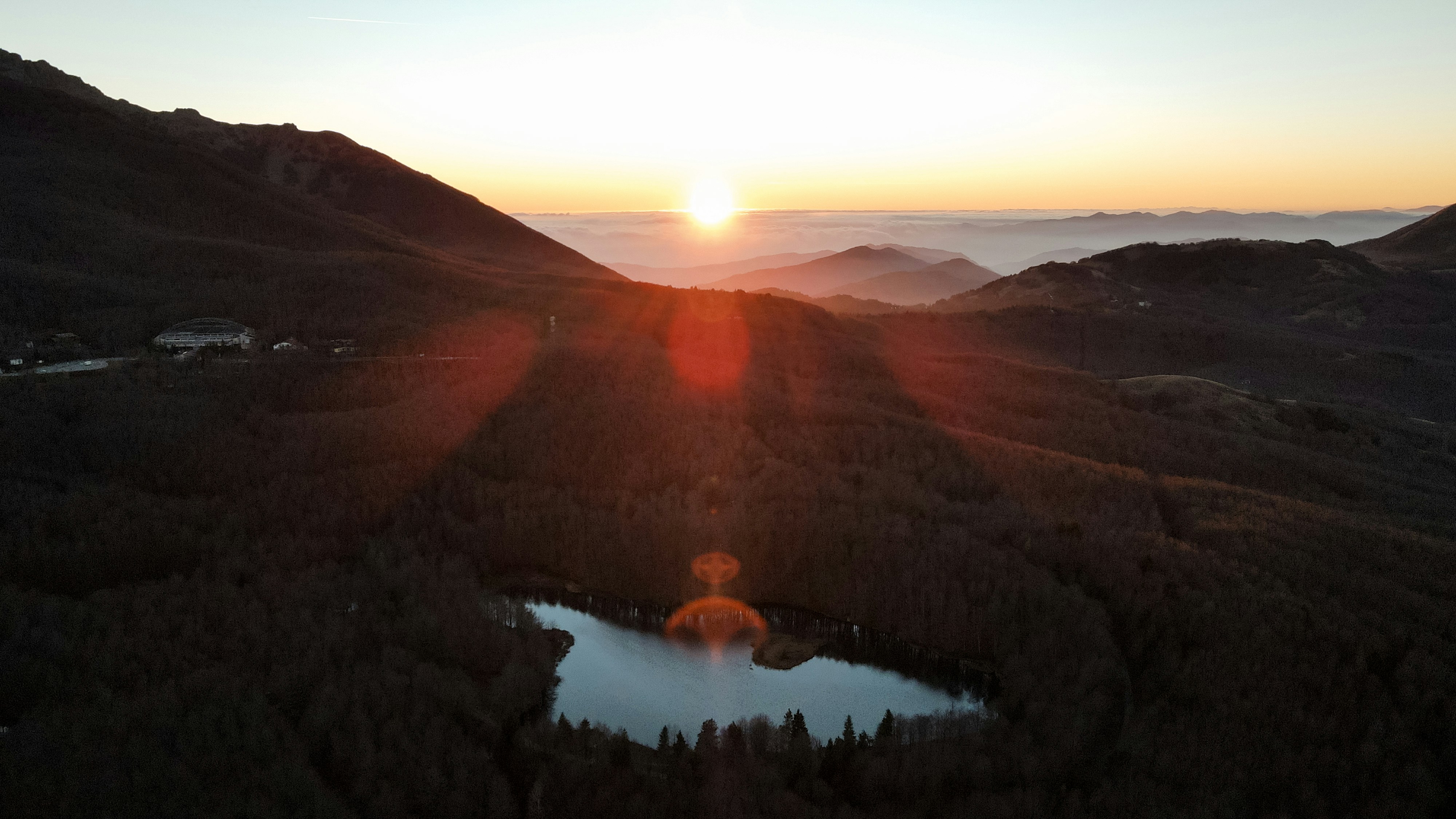 Horizon Fire Over a Winding Valley Lake