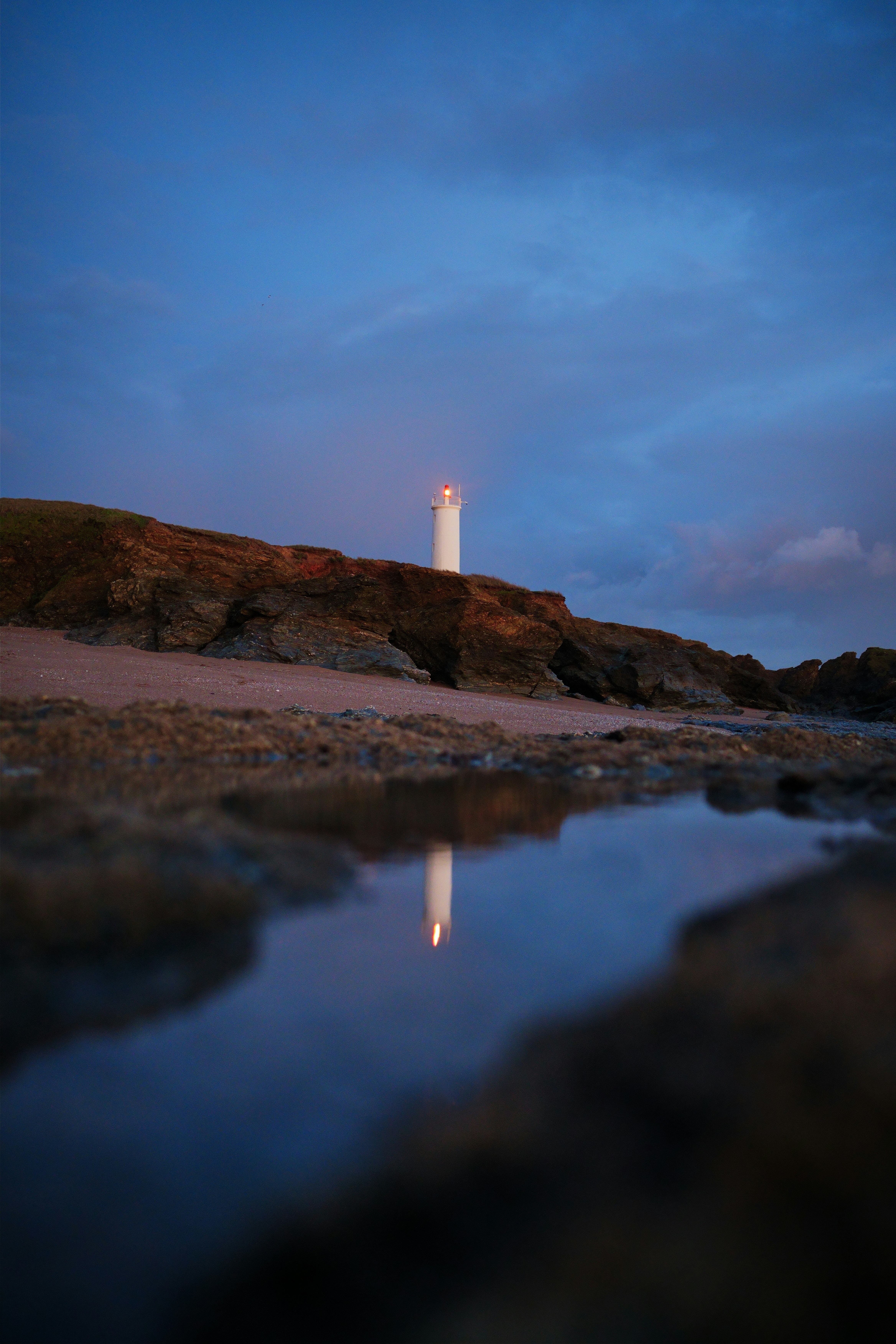 Beacon on the Edge: A Coastal Night with Silent Reflections