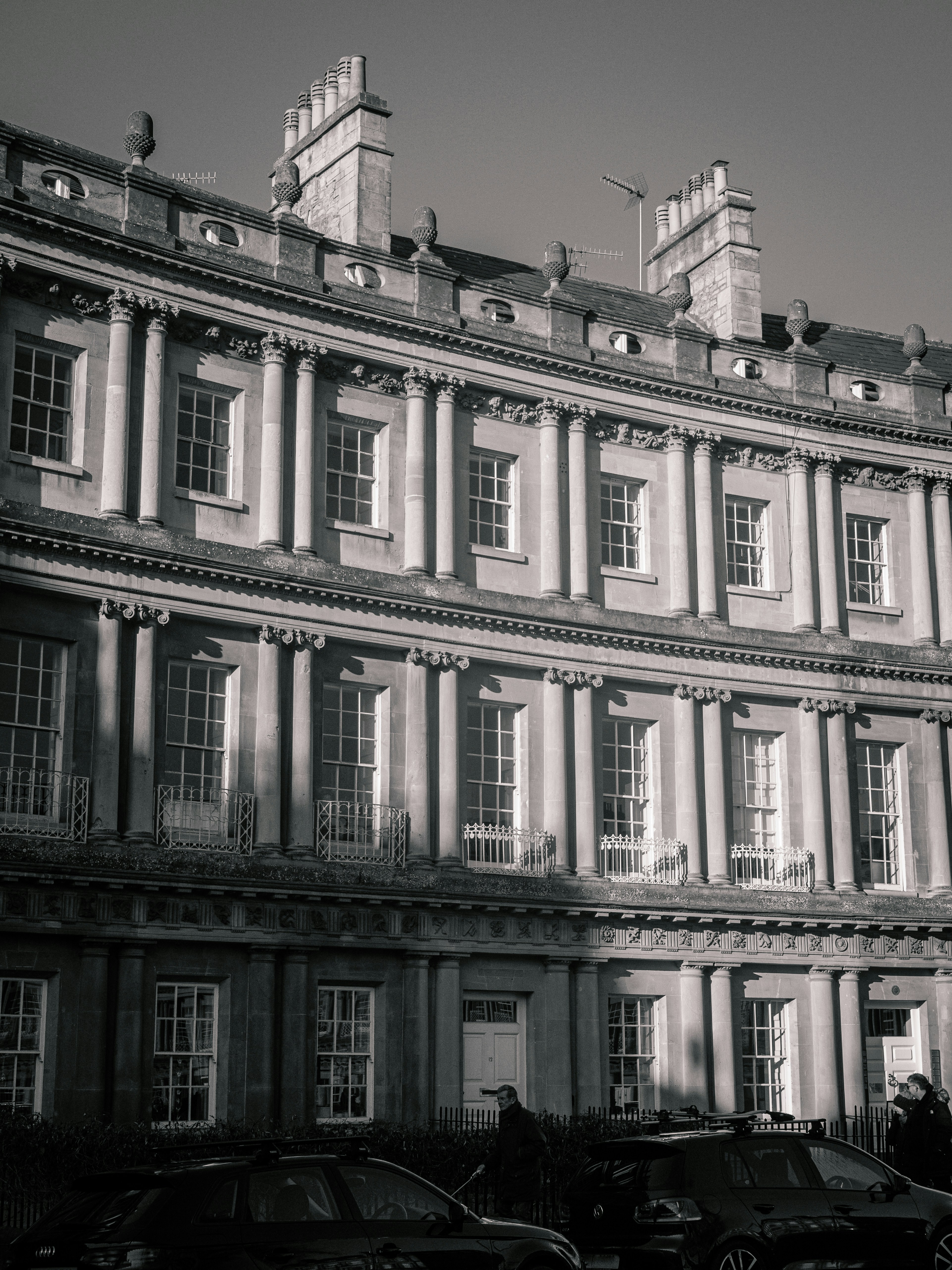 Historic building facade with intricate columns and large windows, captured in black and white.