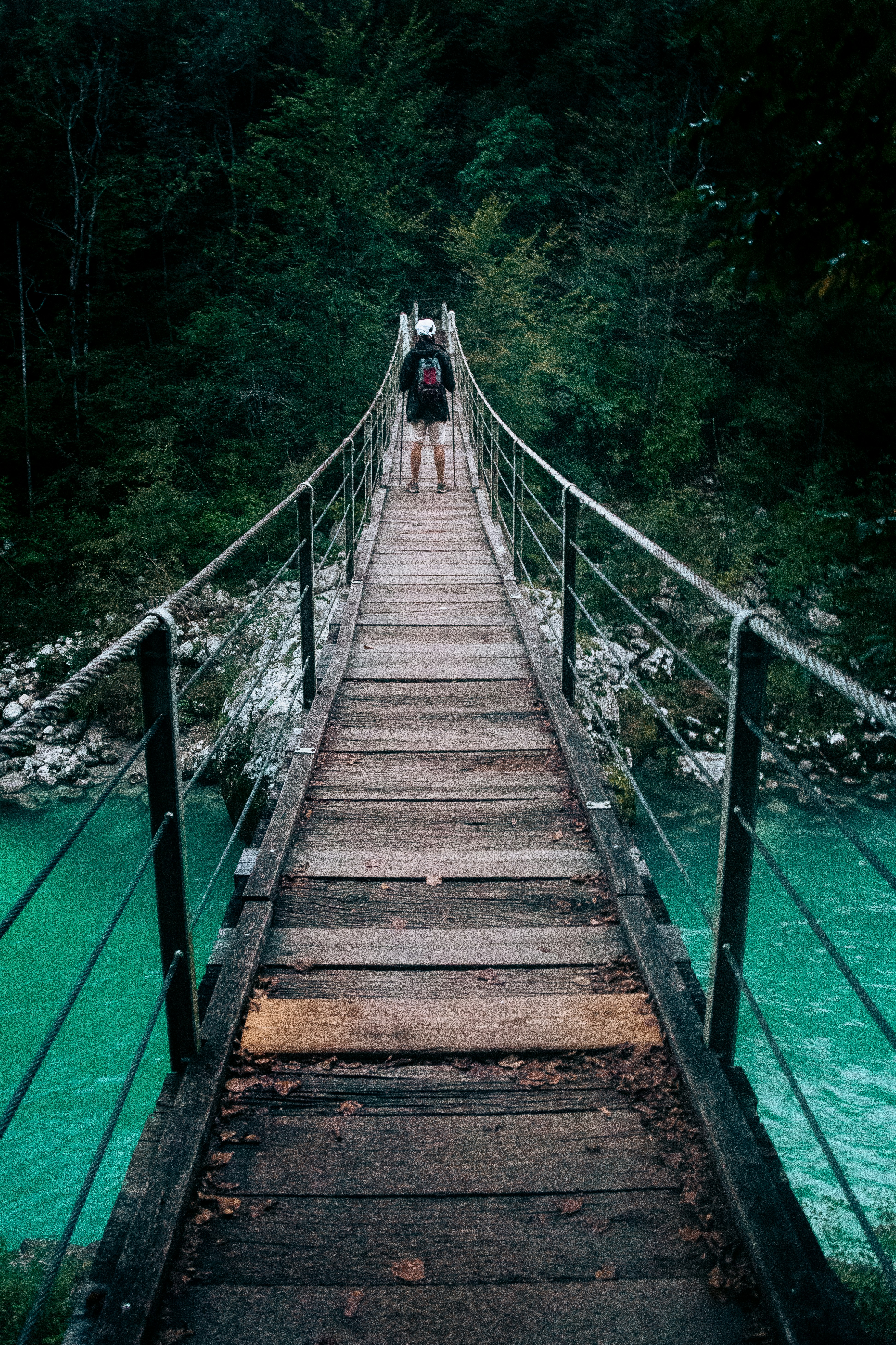A person walking across a bridge over a river photo – Free Land Image ...