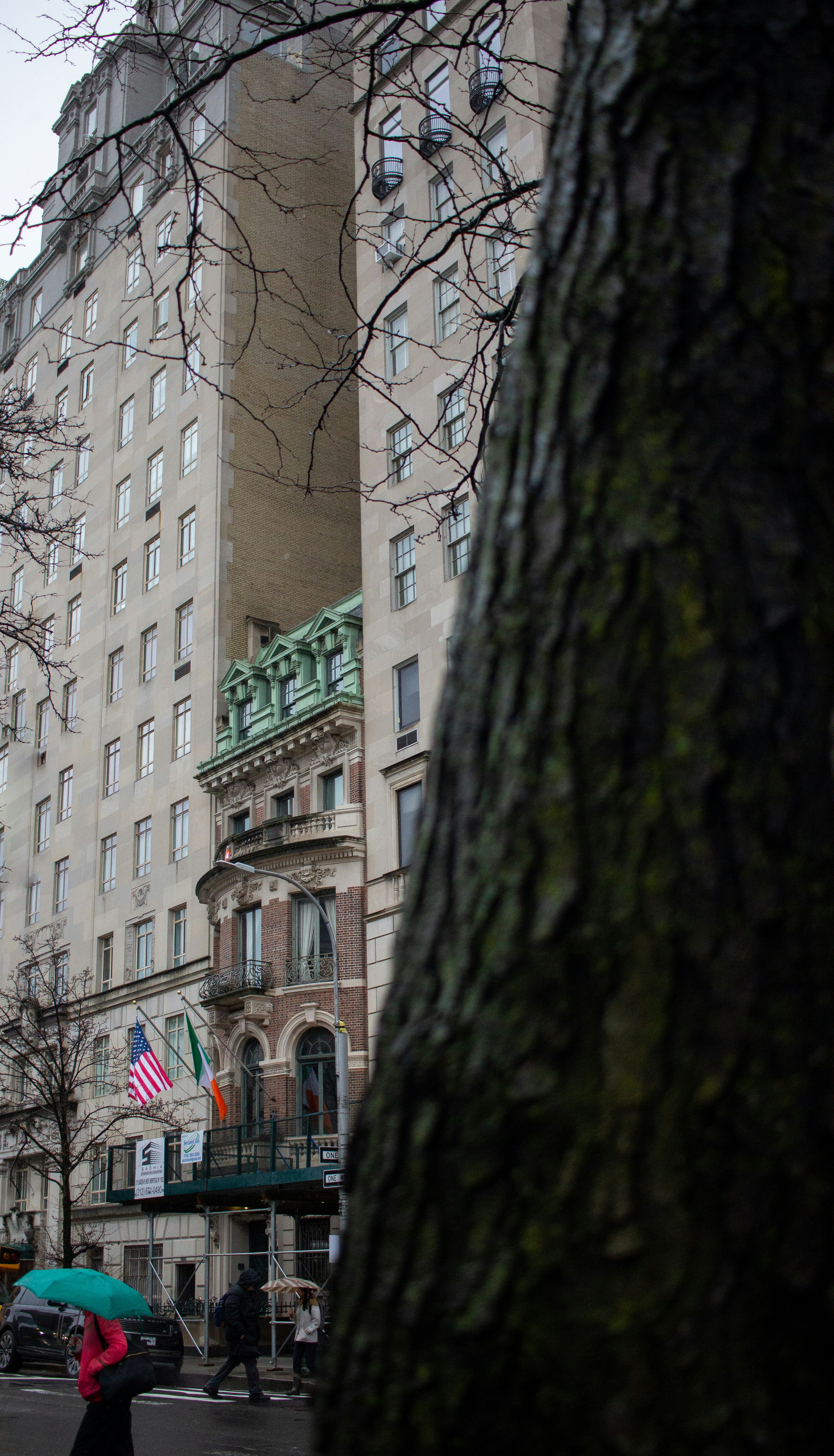 Green Copper Roofed Entrance Between Towers on a Rainy City Street