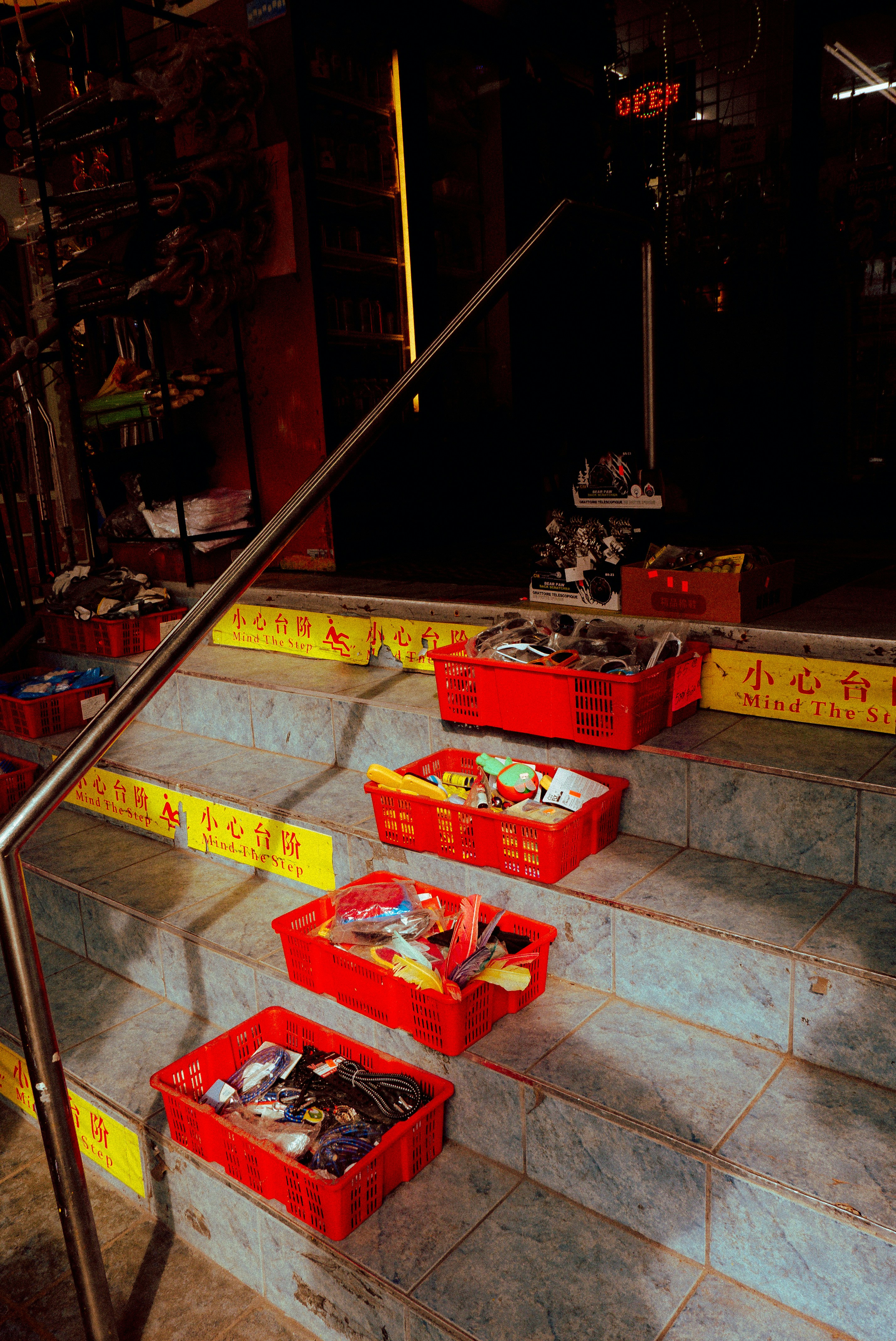 Red Baskets on Neon Night Steps by a Dim Shopfront