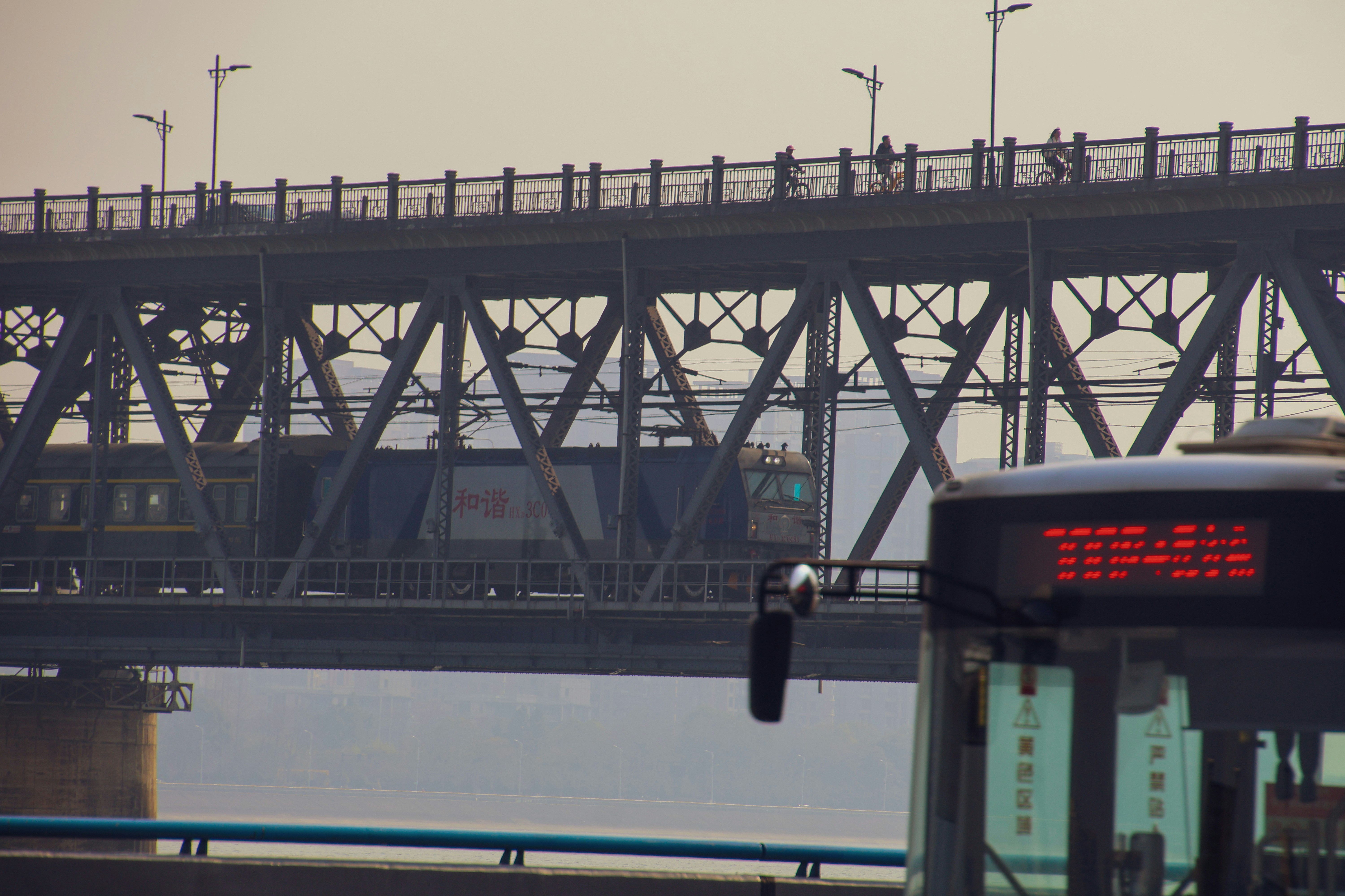 Across the Lattice: A Train Traverses a Steel Bridge at Dusk