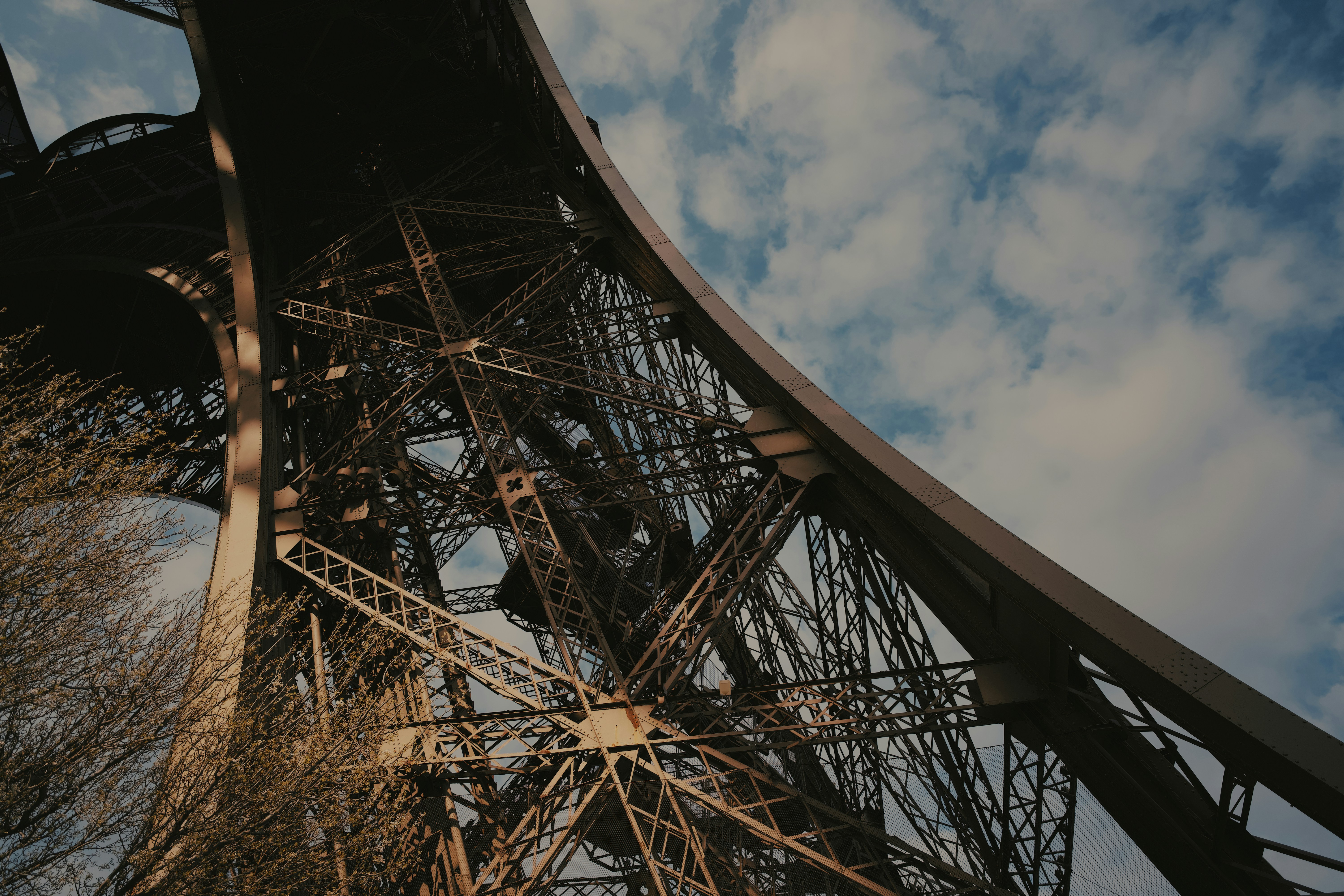 Crisscrossed Ironwork Beneath a Blue Sky: A Low-Angle Bridge Detail
