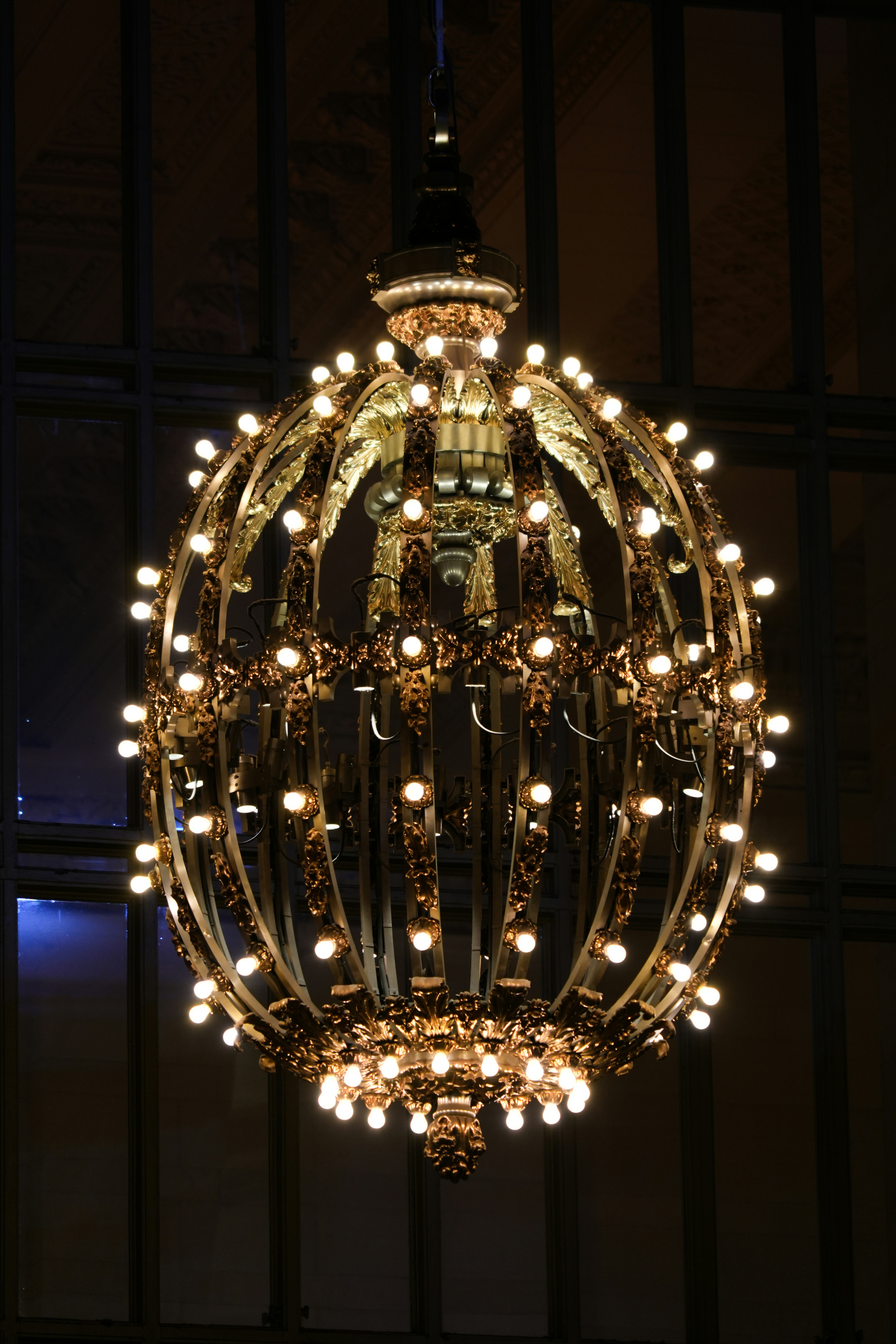 Orbital Globe Chandelier Illuminating a Velvet-Dark Interior