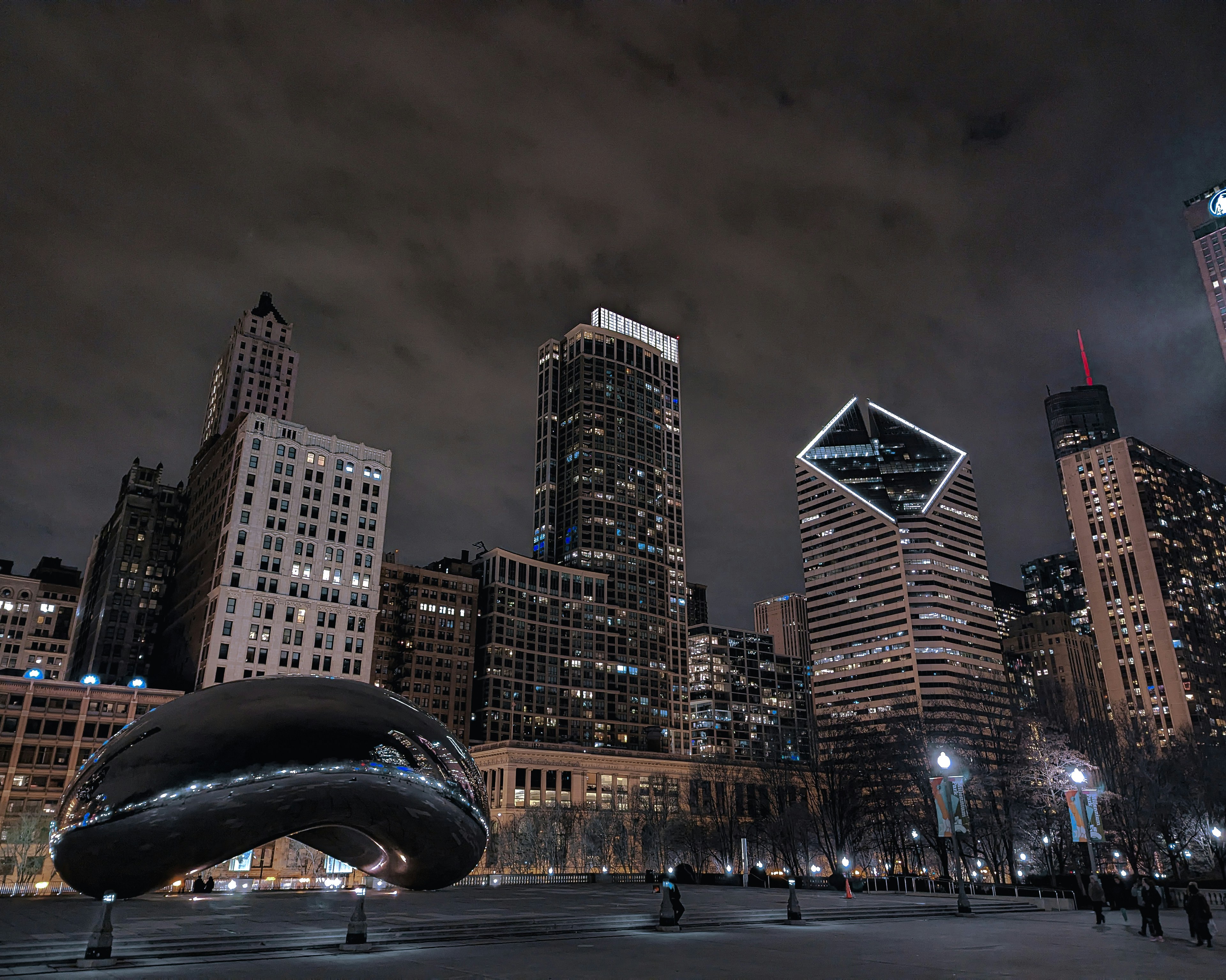 Nighttime Skyline with Reflective Sculpture in Foreground