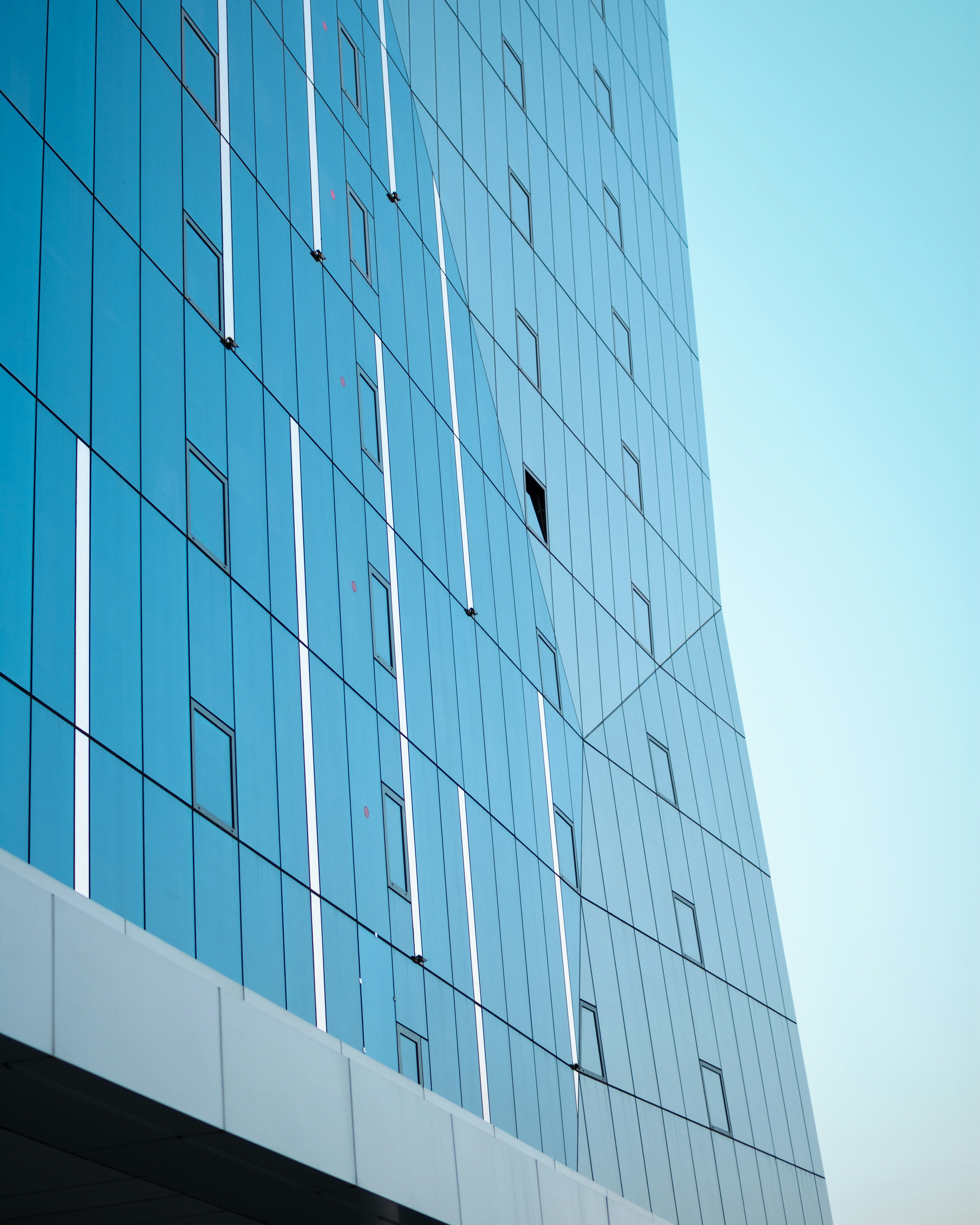 A tall building with a hole in the side of it photo – Free City Image ...