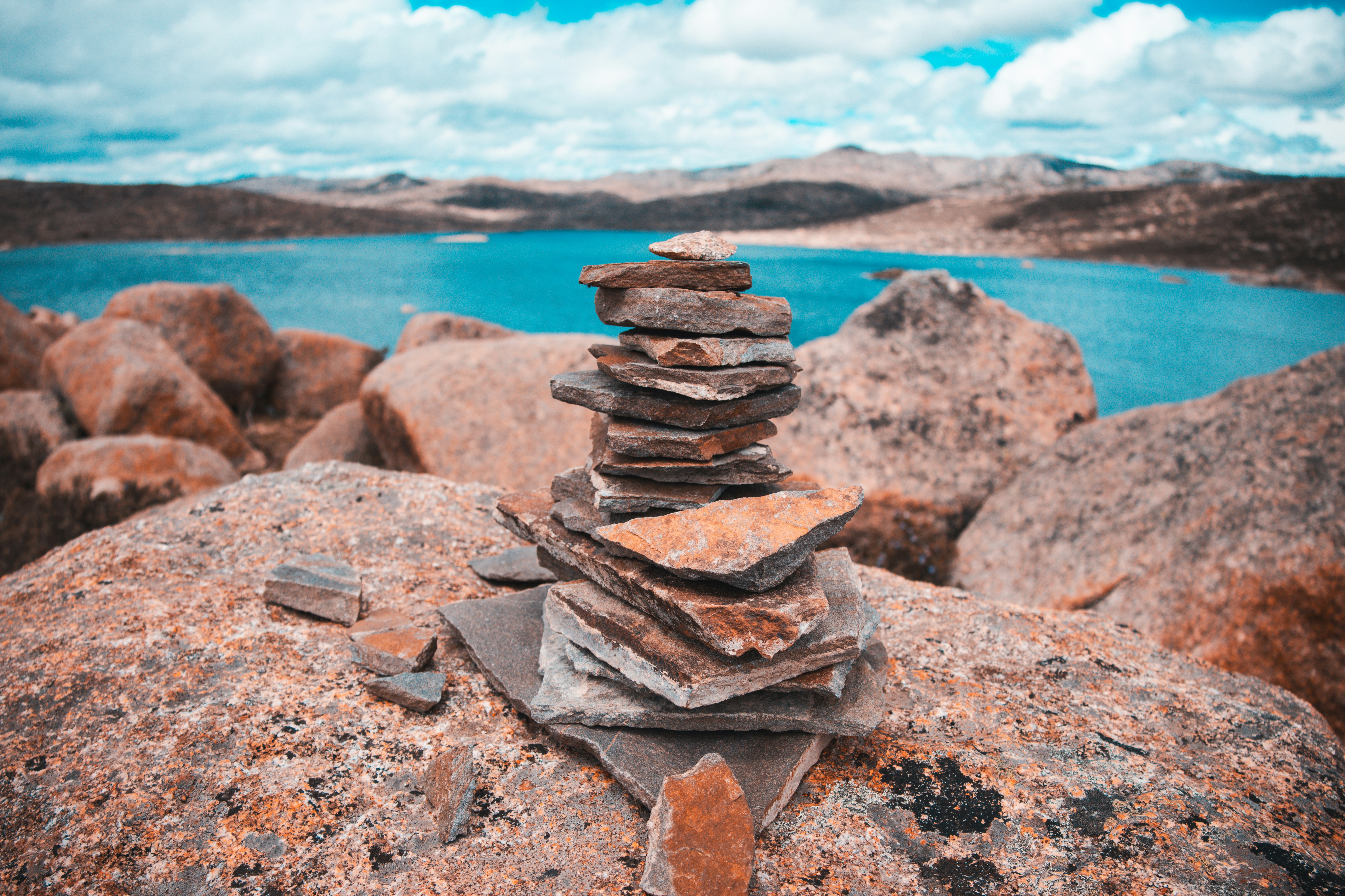 A stack of rocks sitting on top of a large rock photo – Free Garzê ...